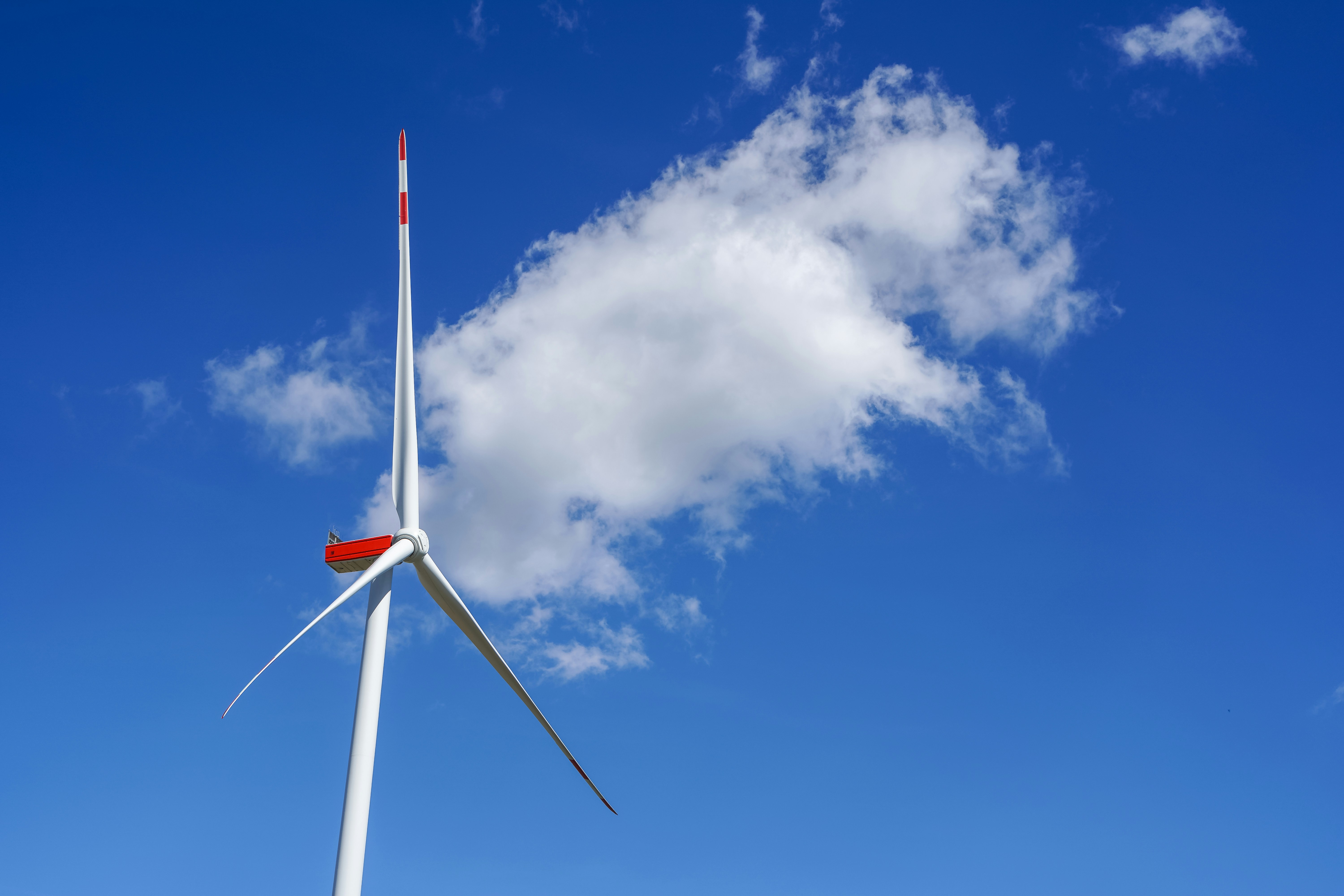 Windward Sentinel: A Wind Turbine Piercing a Clear Blue Sky