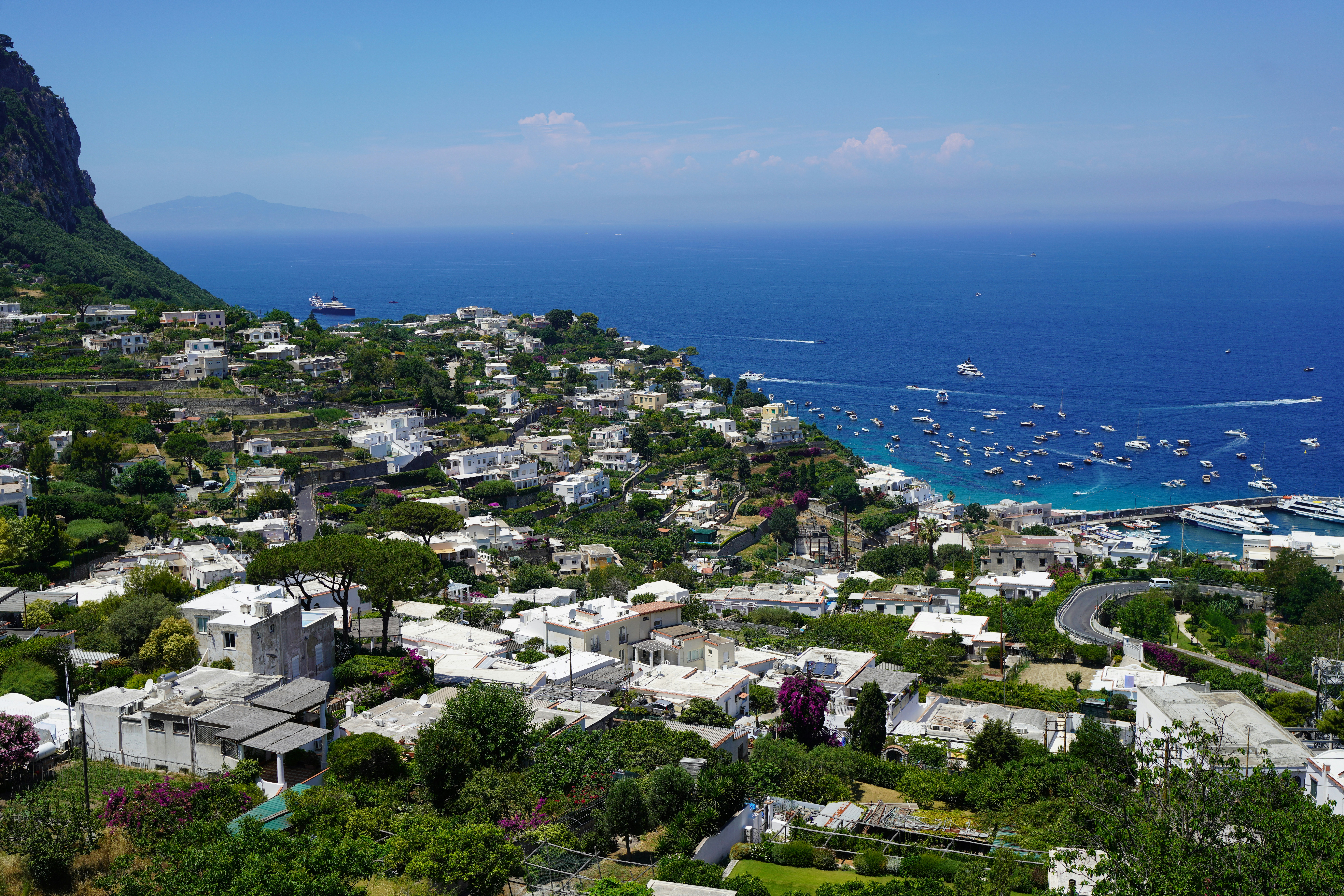 Harbor village sunlit hillside framed by blue expanse