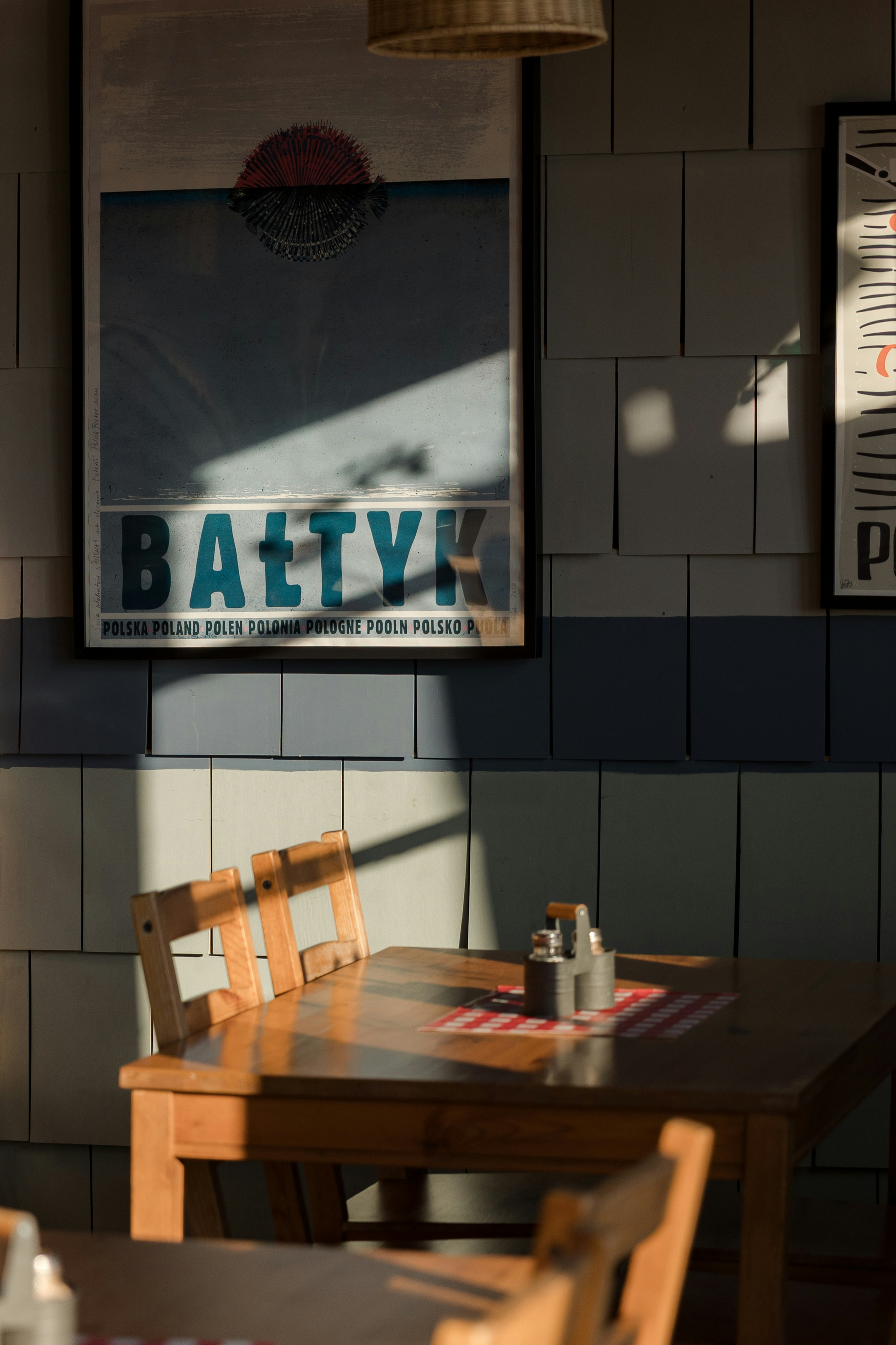 Sunlit Corner Café: Shadows, Posters and Wooden Tables
