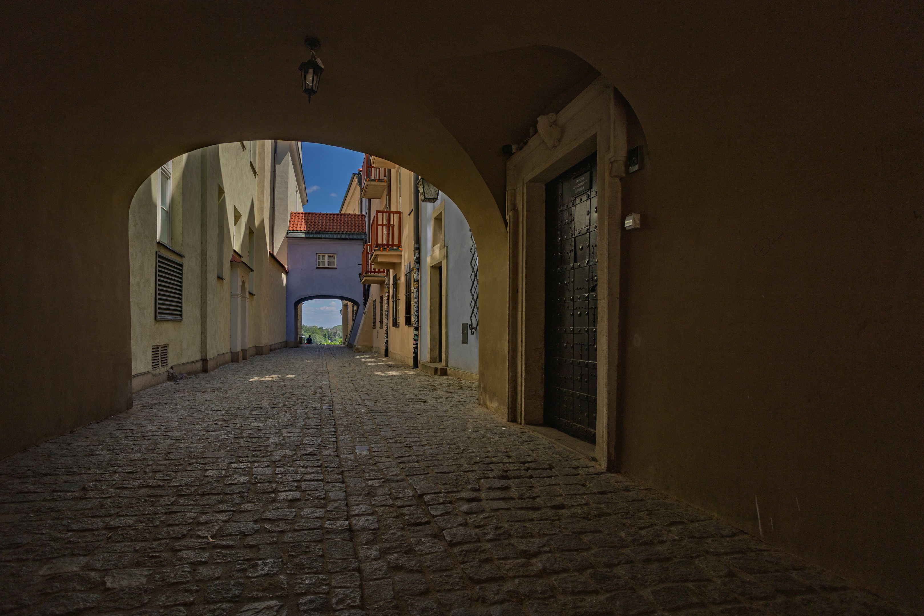 Archway to the Light: Cobbled Alley into a Sunlit Town