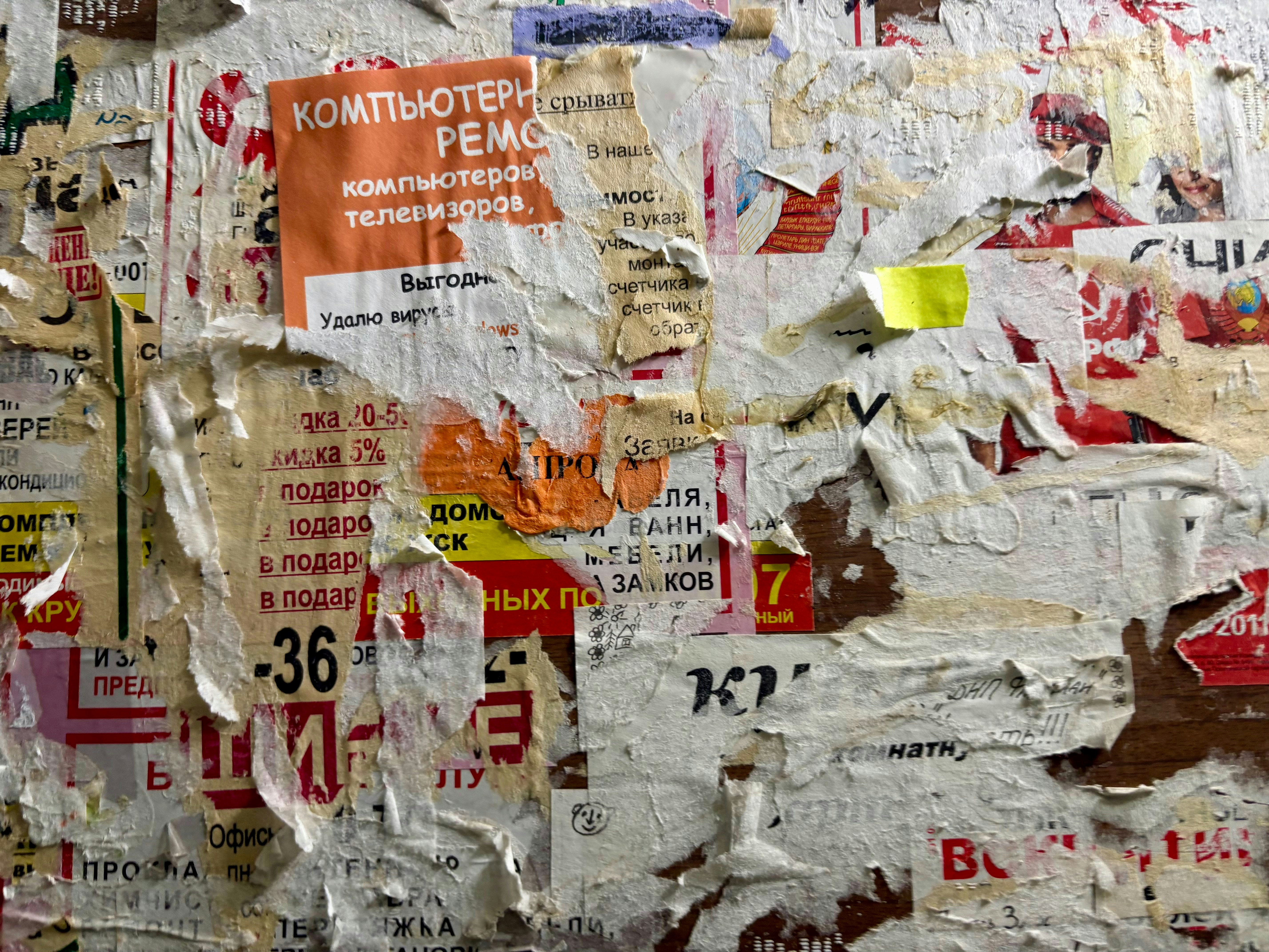 Layered Echoes: Torn Posters on a Weathered Wall