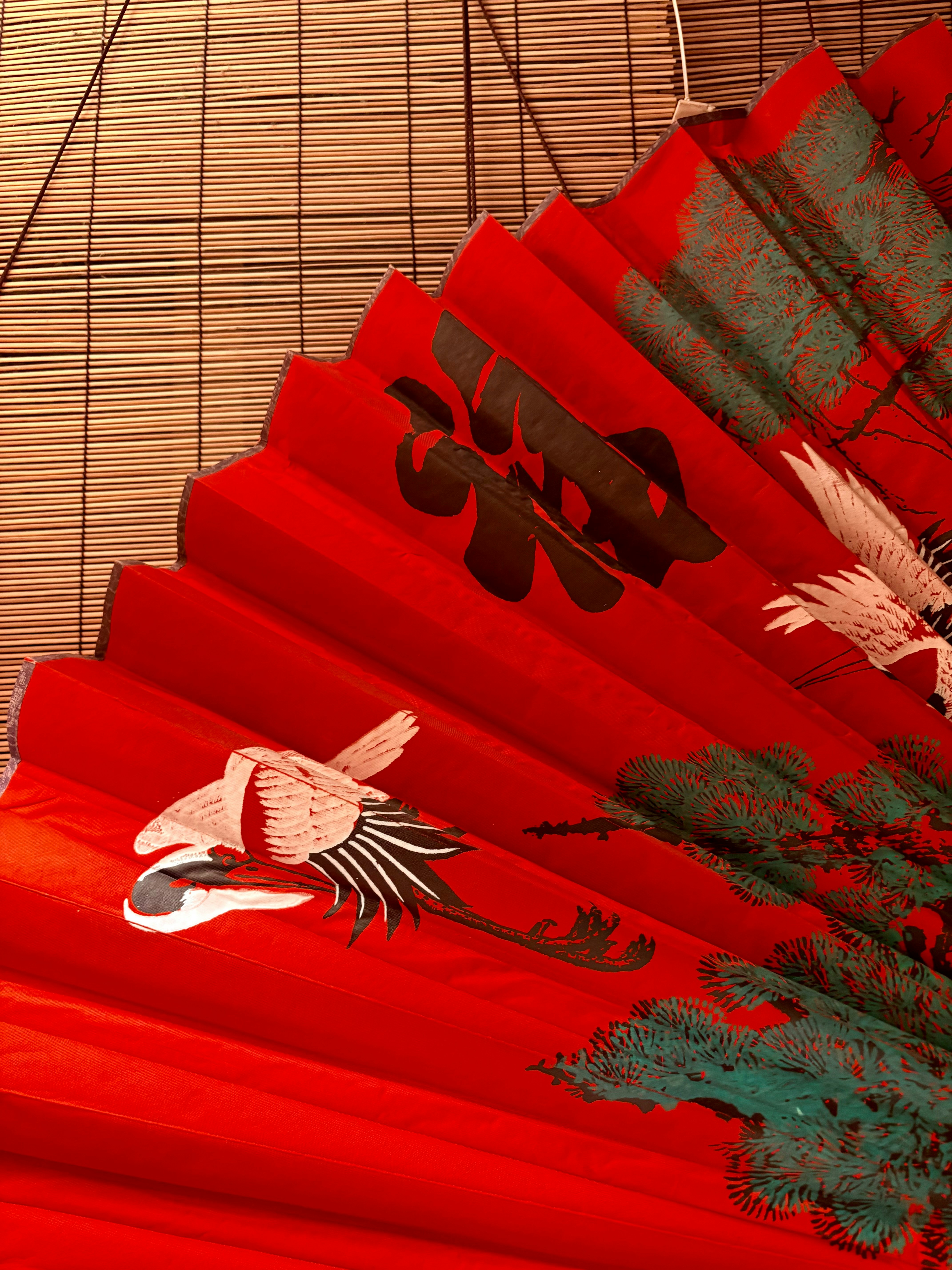 Crimson Fan of Tradition: A Folded Red Lantern with Painted Crane
