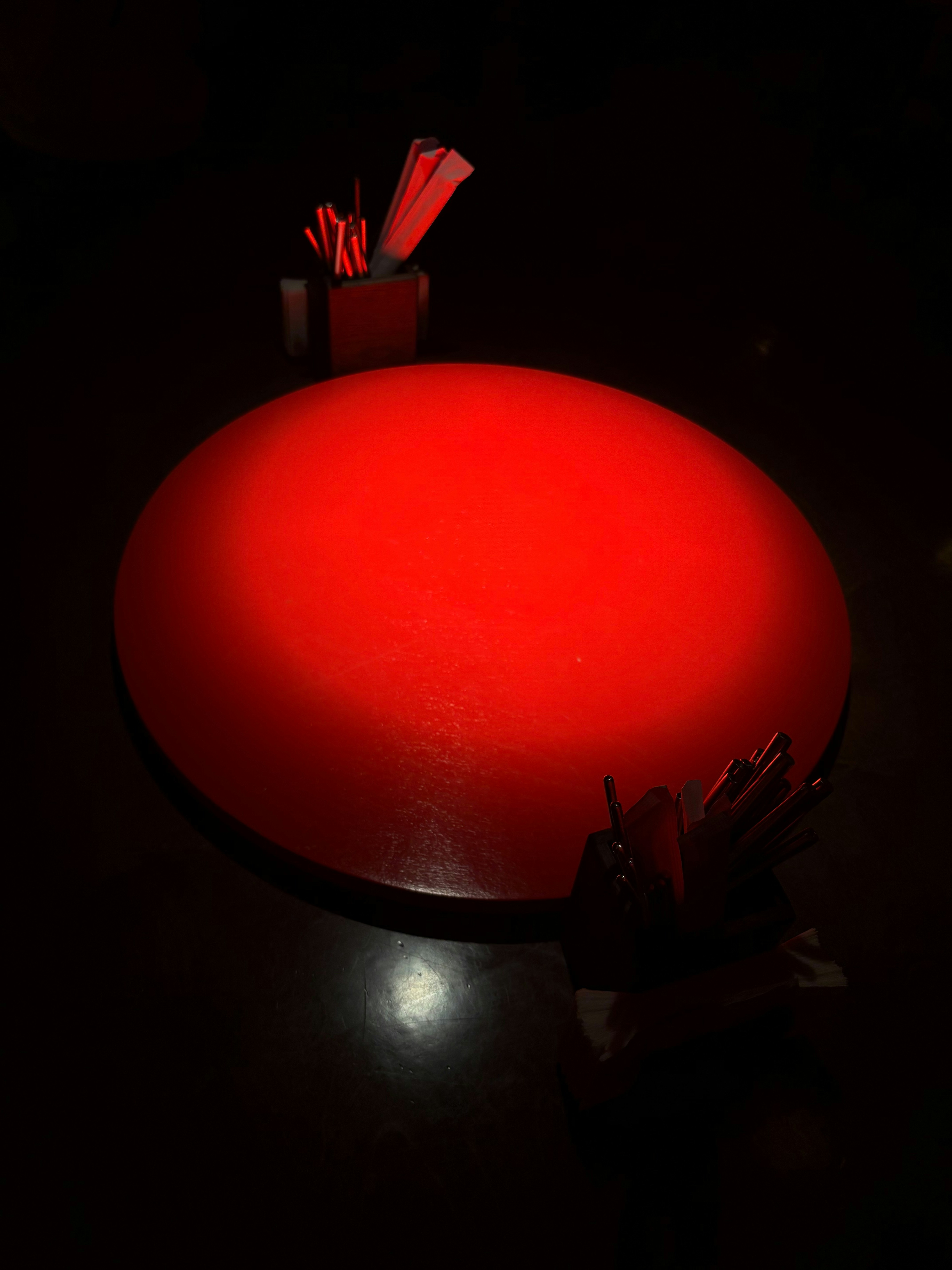 Red Dome at Rest: A Quiet Neon Round Table in the Dark