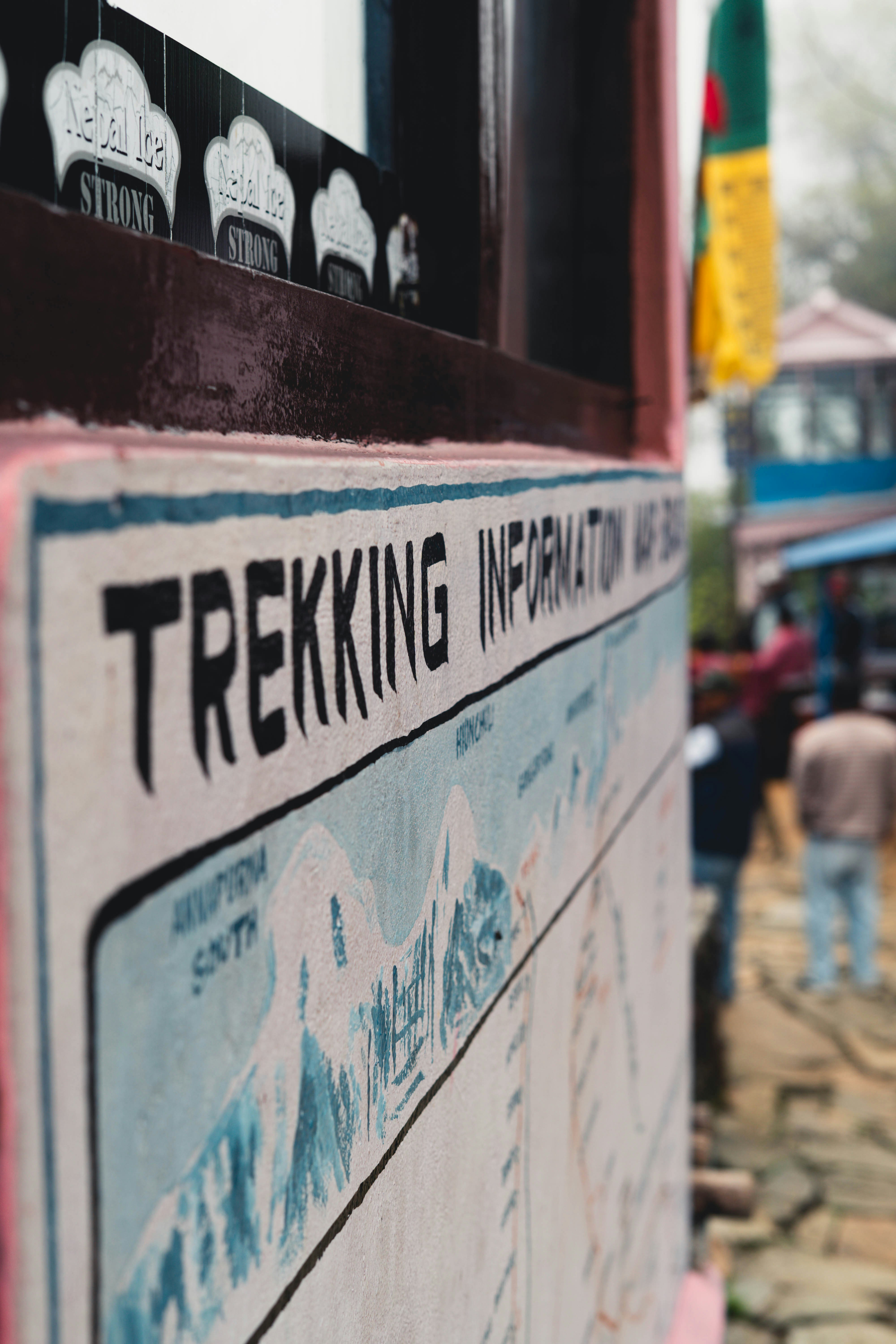Trailhead Signage: Trekking Information at a Busy Market Entrance