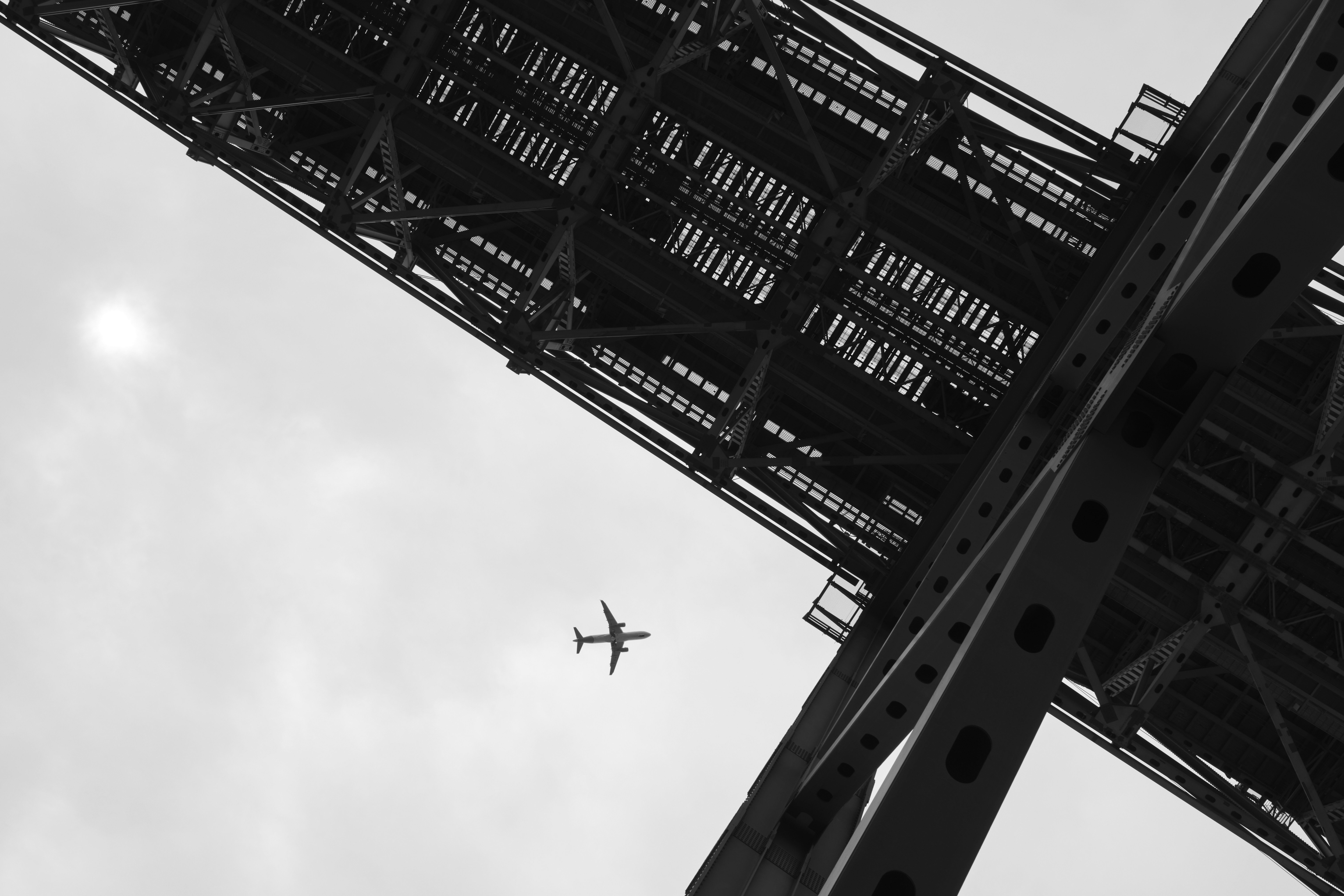 Aerial Arrow: A Plane Quietly Traverses a Steel Sky