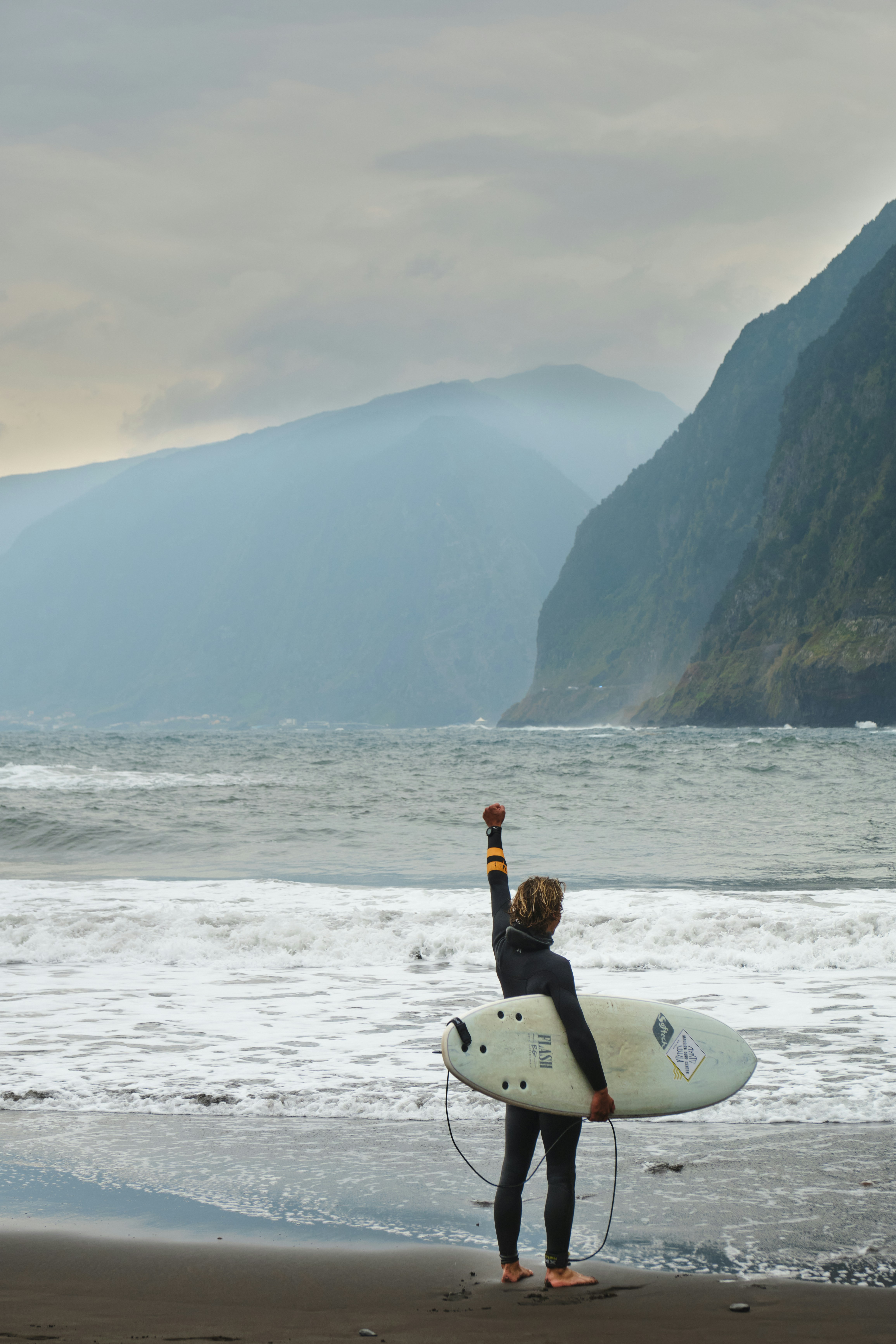 Surfer’s Silent Triumph at a Misty Coastal Gate