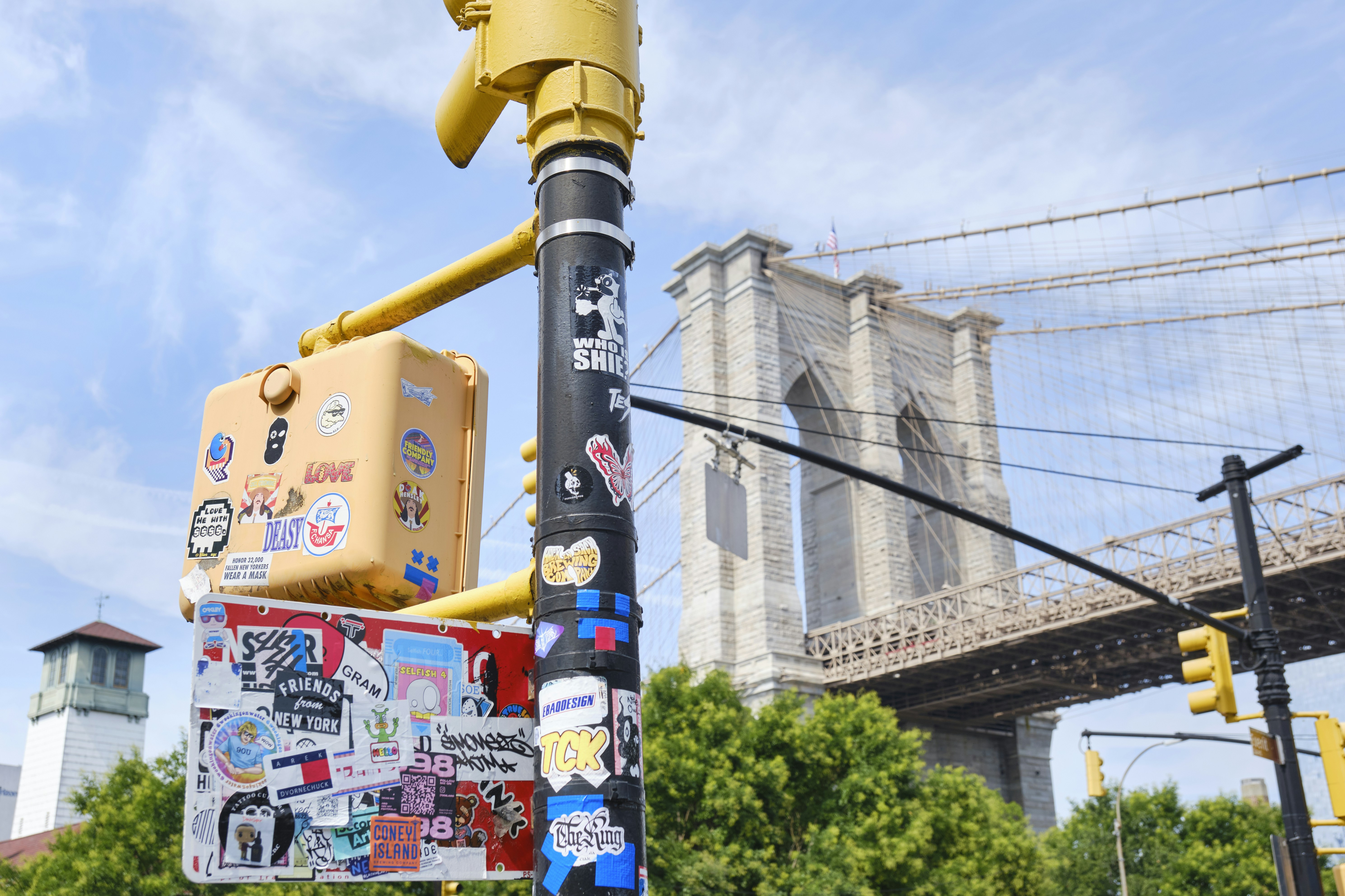 Stickered Street Pole at the Edge of the Cityscape