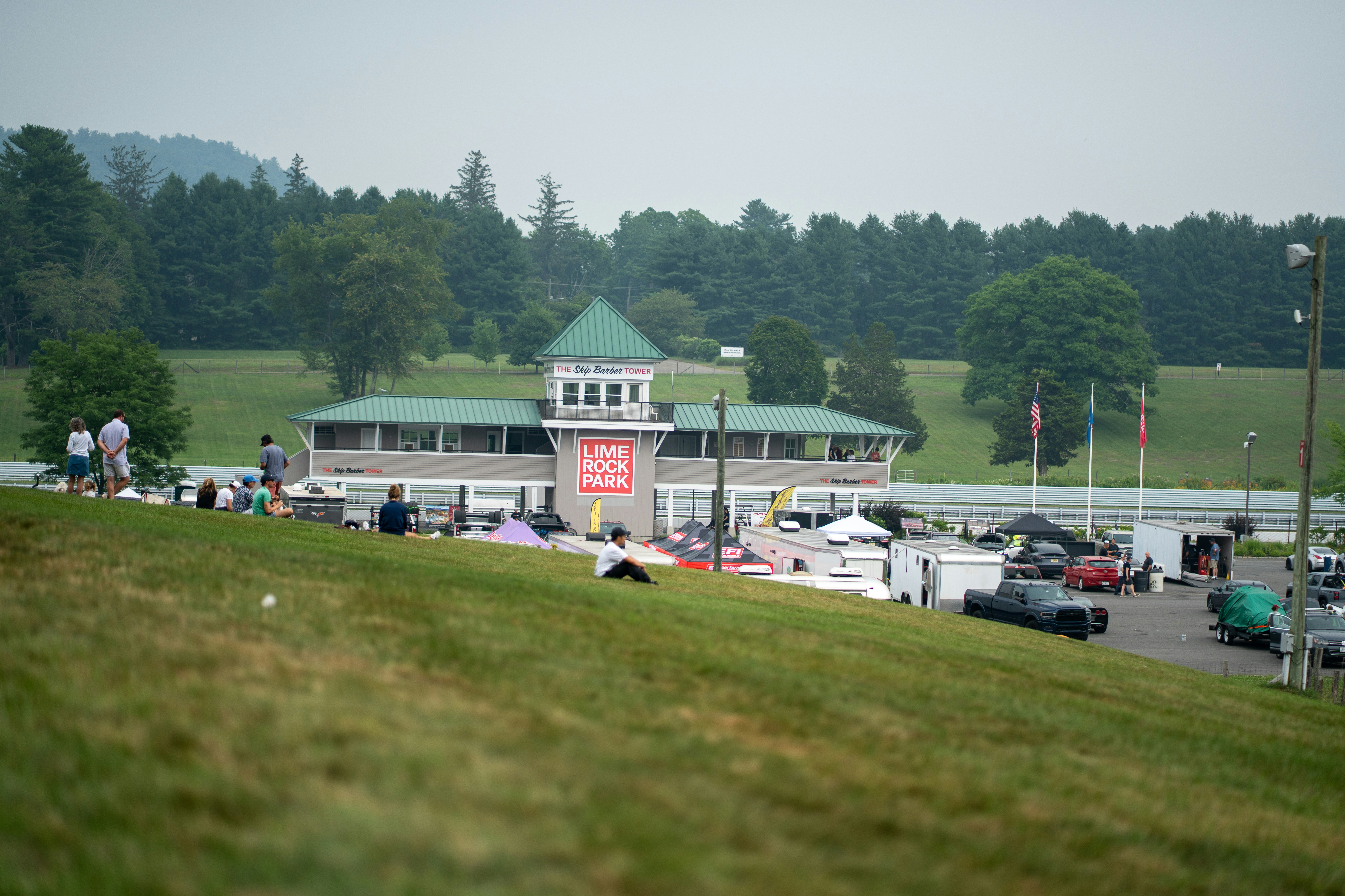 Grassfield Grandstand: People, Cars, and a Scenic Park View at the Racecourse