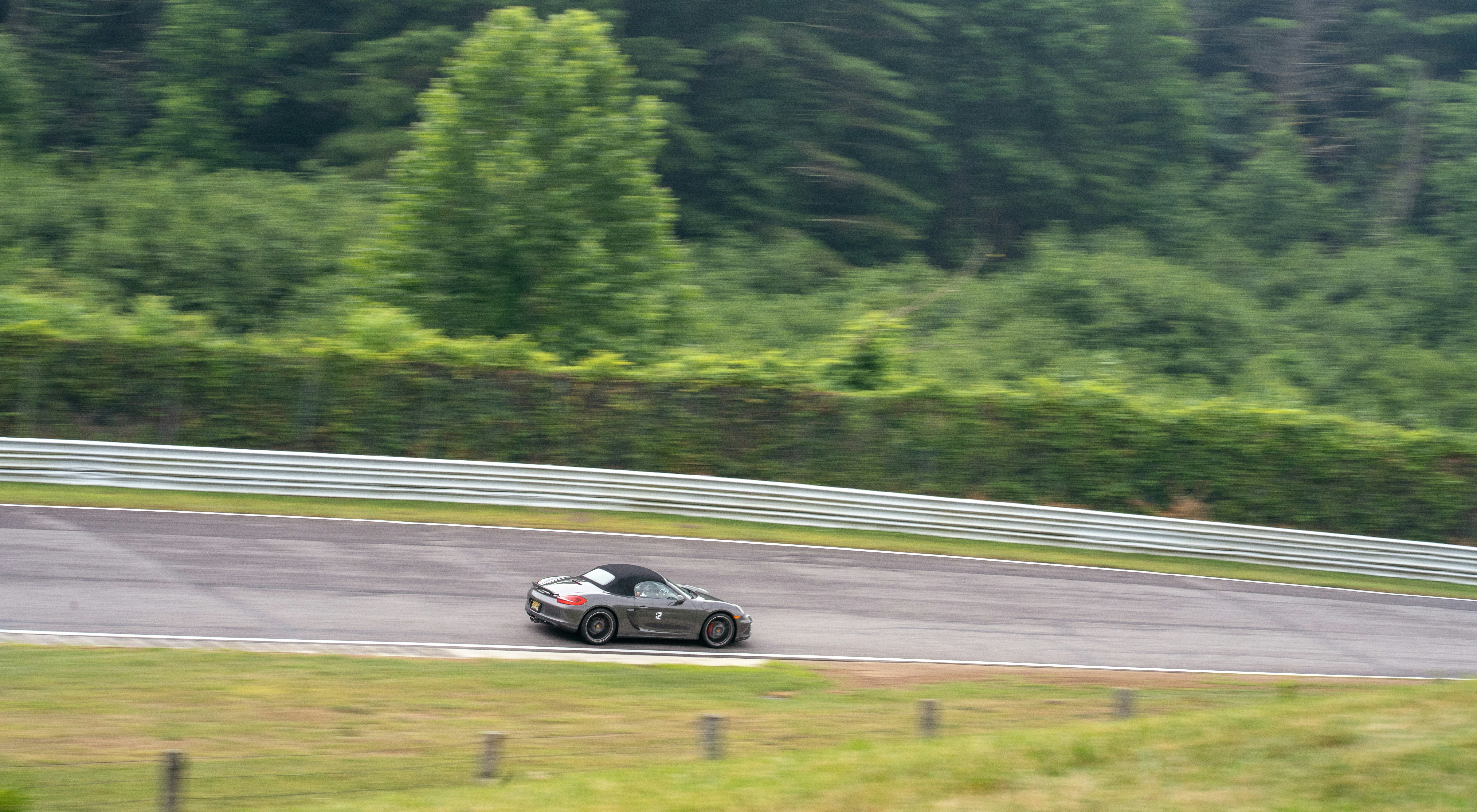 Silver Roadster in Motion: A Blur of Green and Gray
