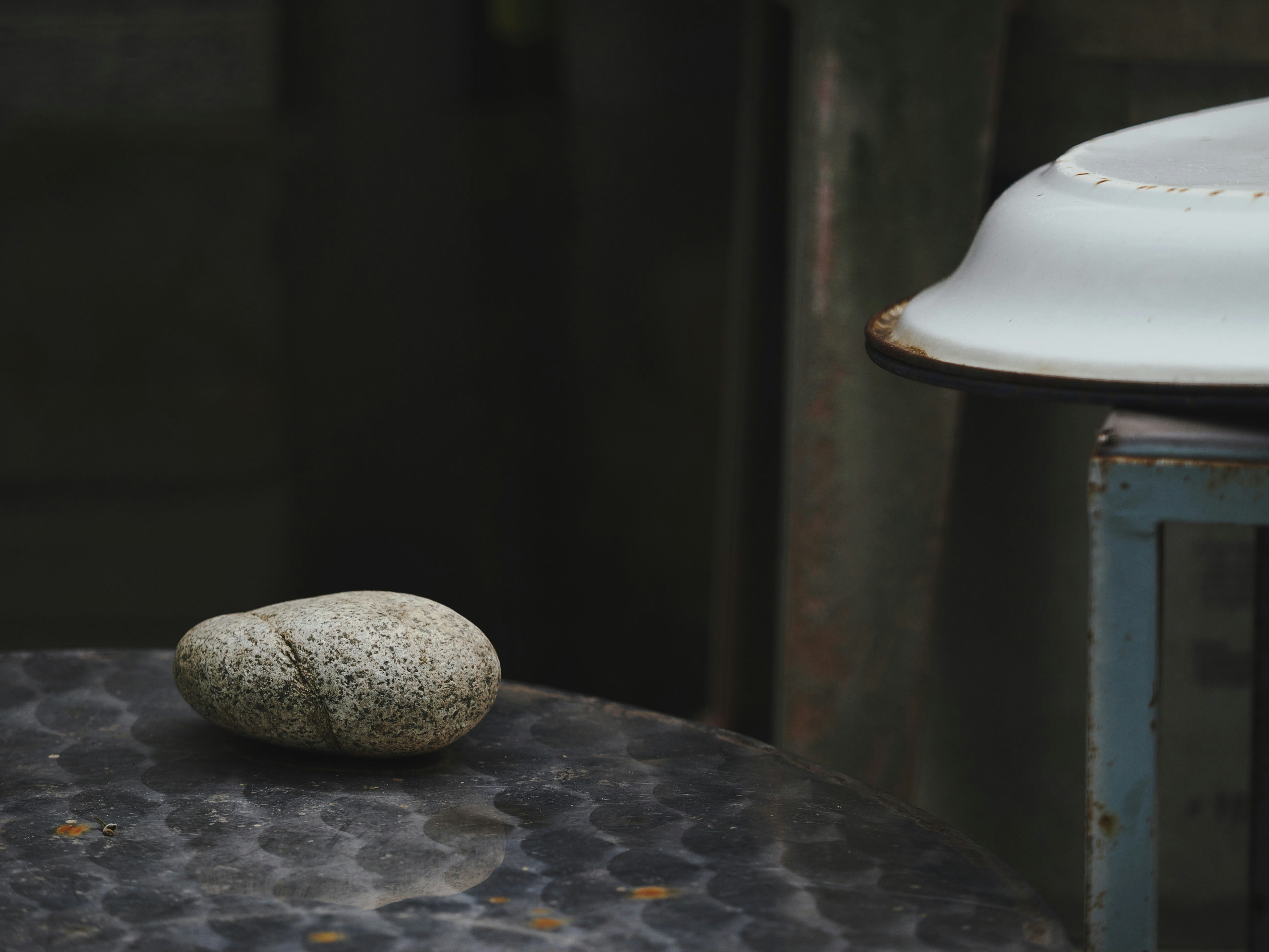 Pebble on a Weathered Table Under Industrial Light