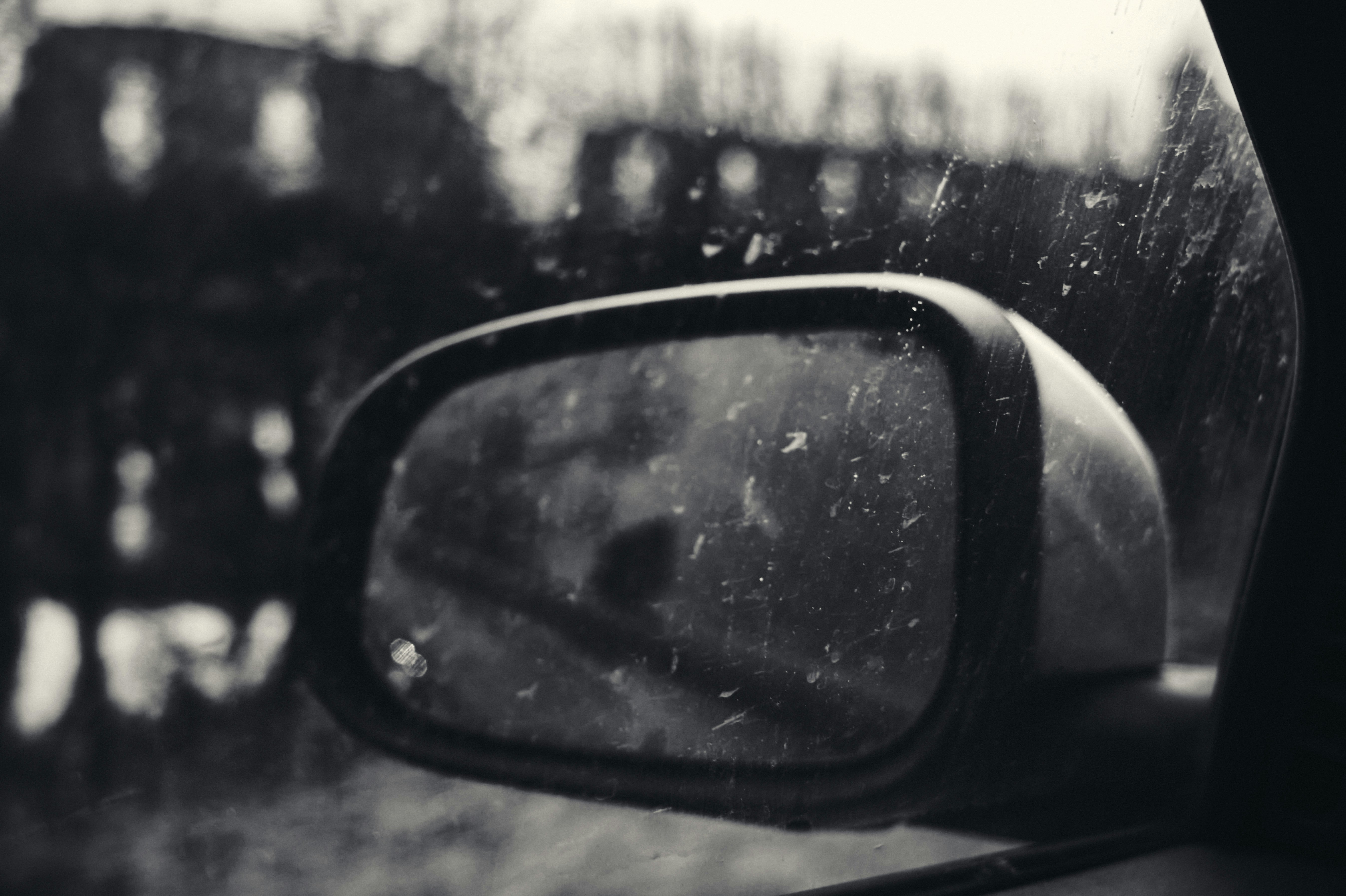 Rearview Mirror in Focus: Raindrops and Blur of Distance