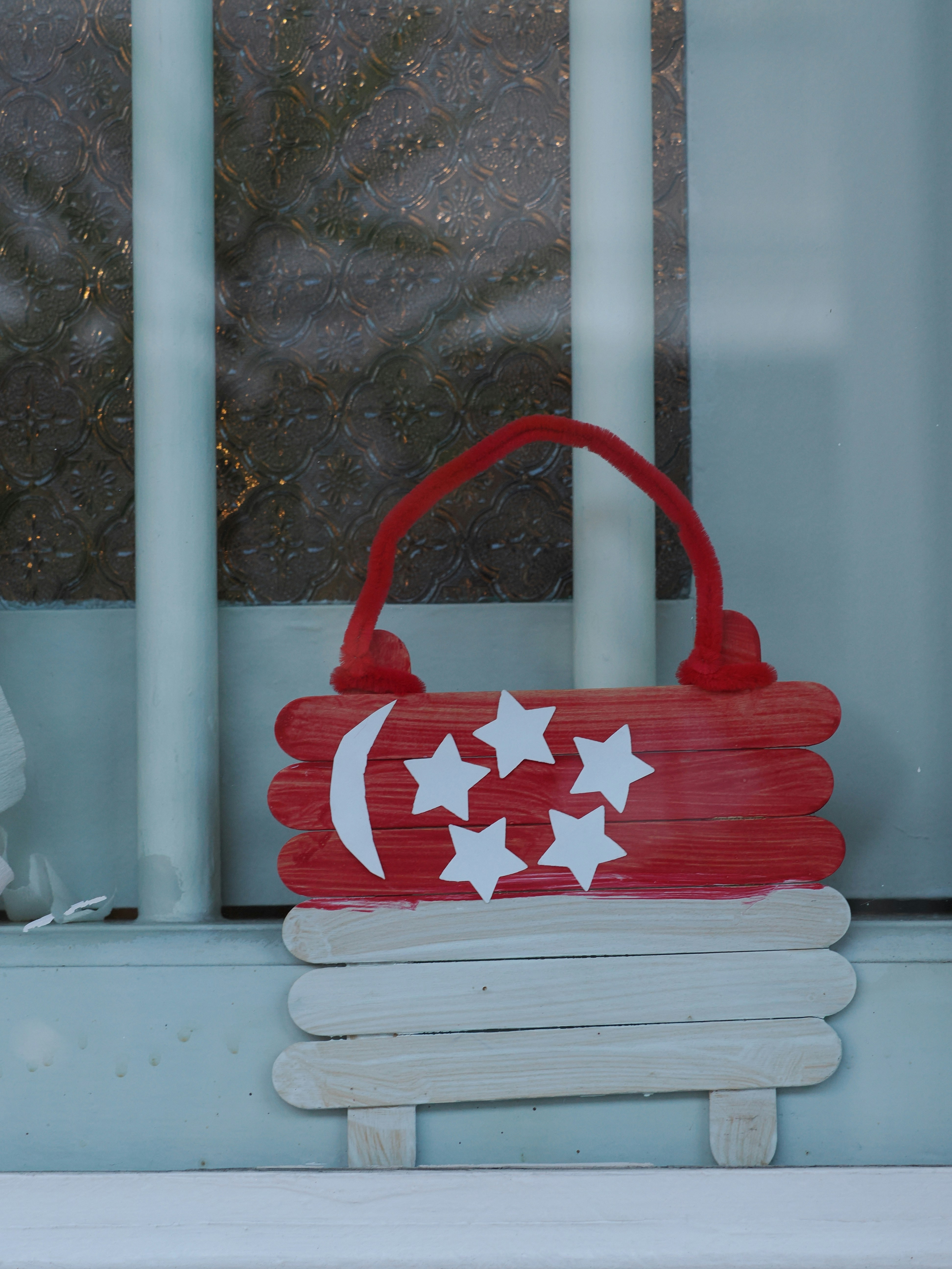 Red Wooden Bag with White Stars Against Pastel Backdrop