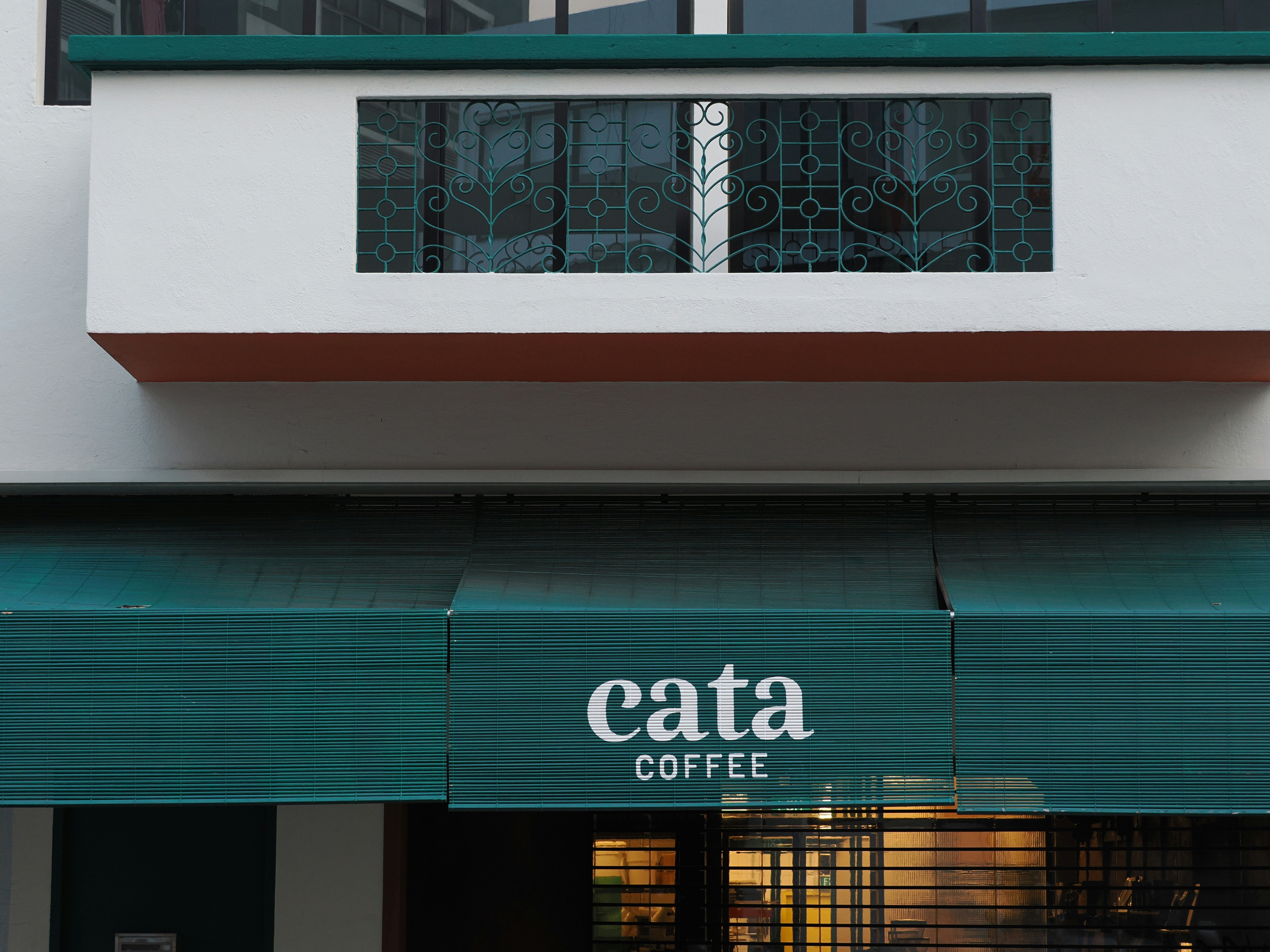 Cascading teal storefront awning over coffee shop sign