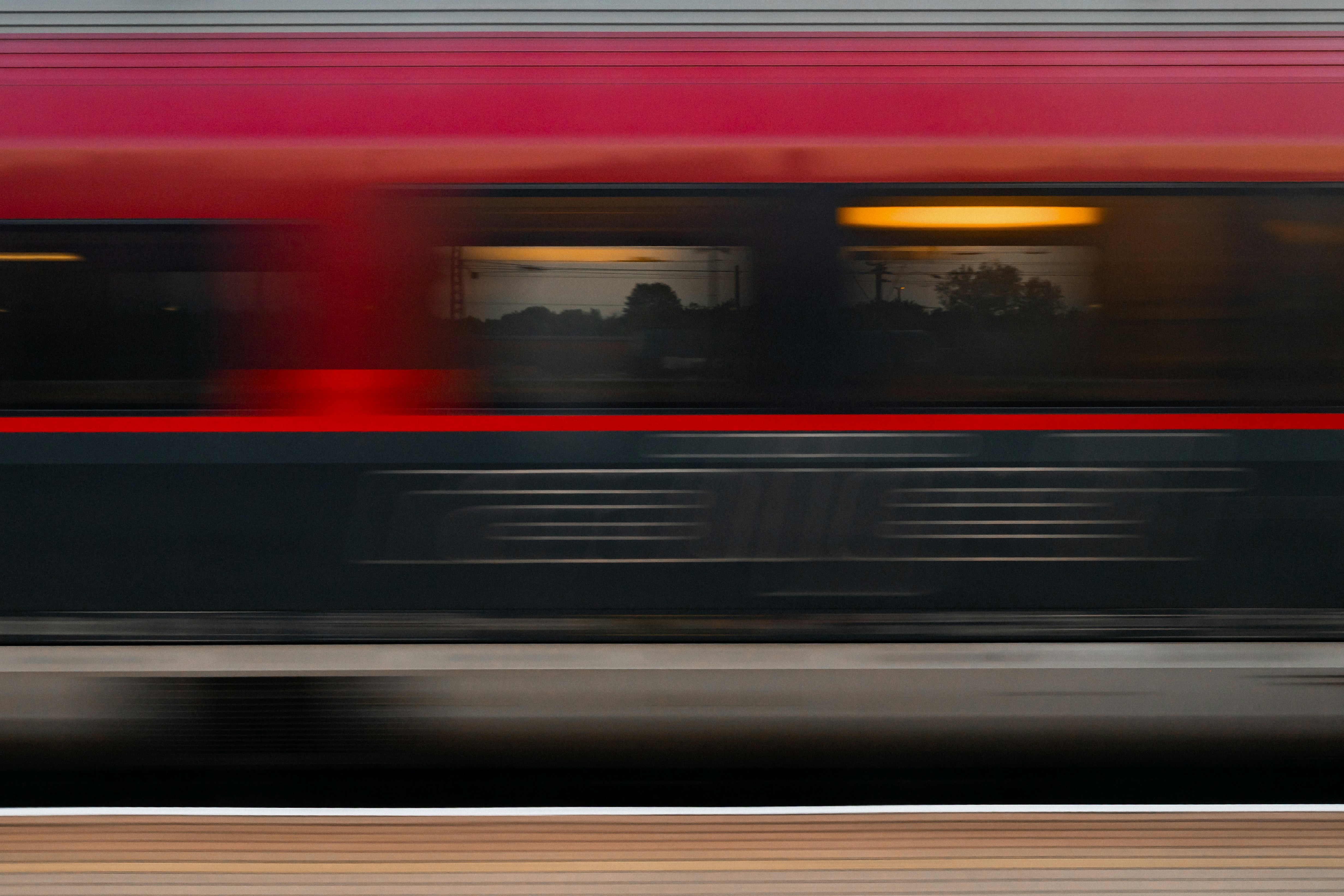 Mid-Train Blur: Red and Black Motion Across the Tracks