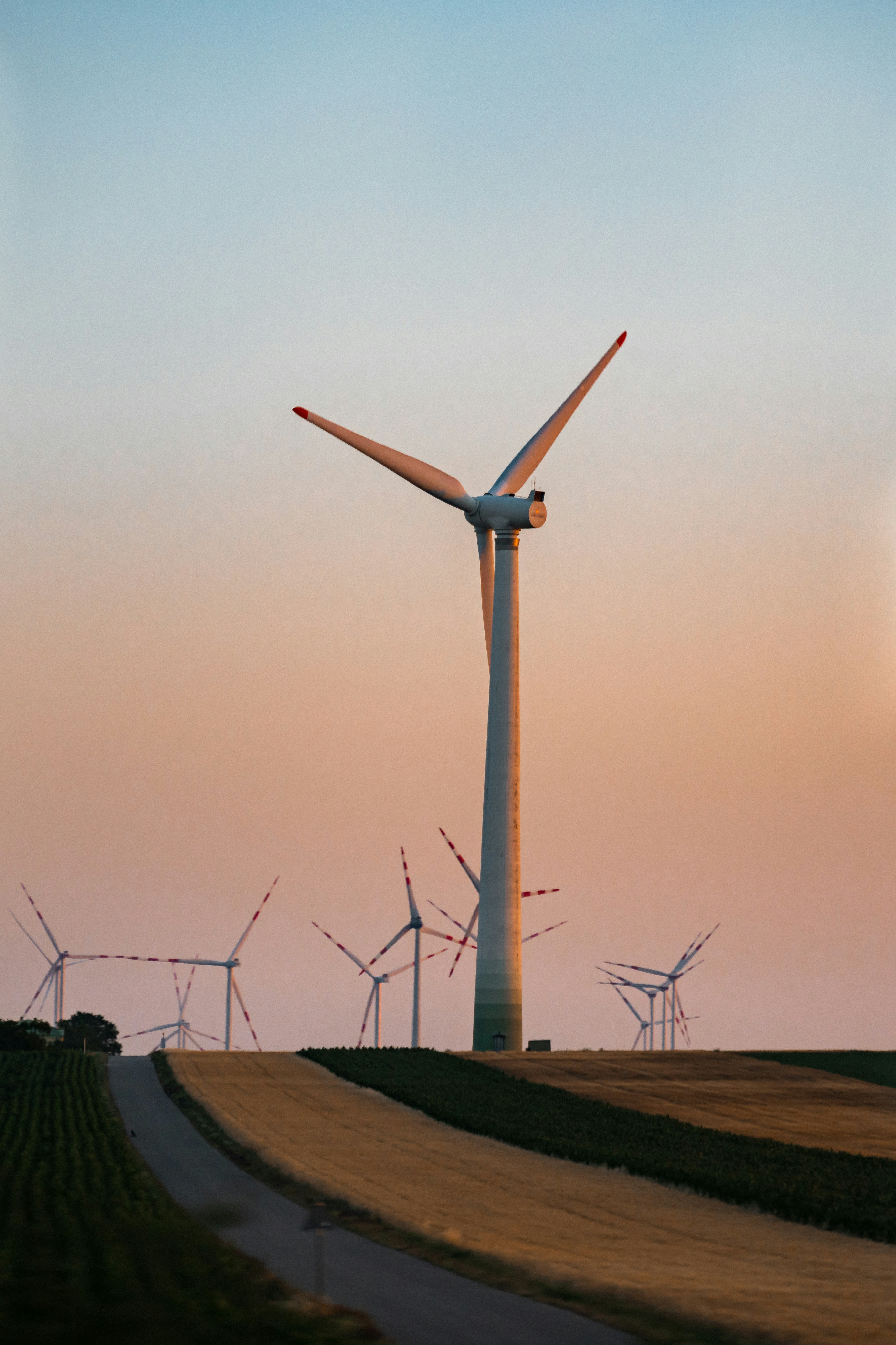 Sunset Field Breeze: A Row of Distant Wind Turbines Standing Tall