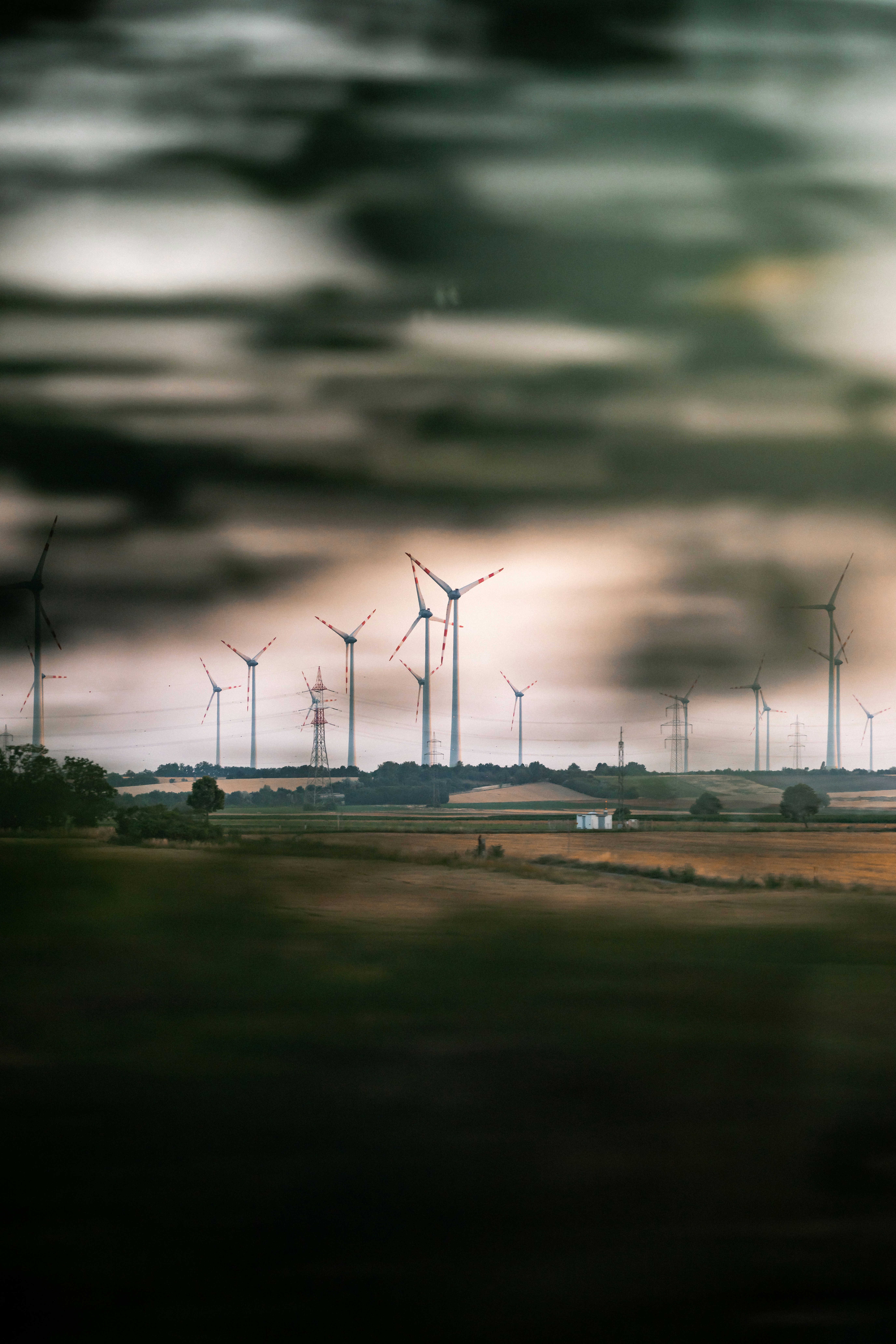Wind Turbines on a Distant Plain under a Blurred Sky
