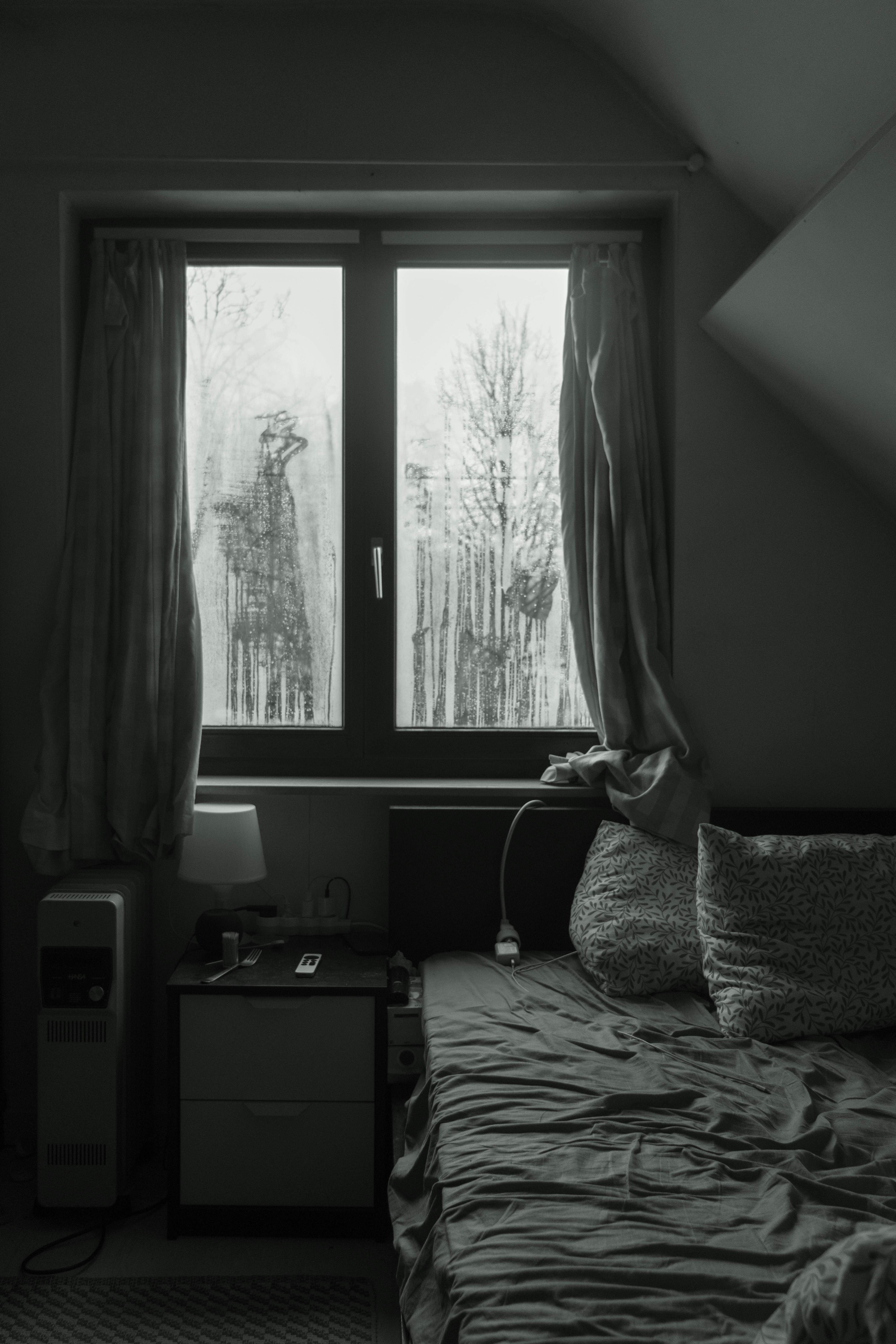 Dimly Lit Bedroom Window: Quiet grayscale morning behind curtains