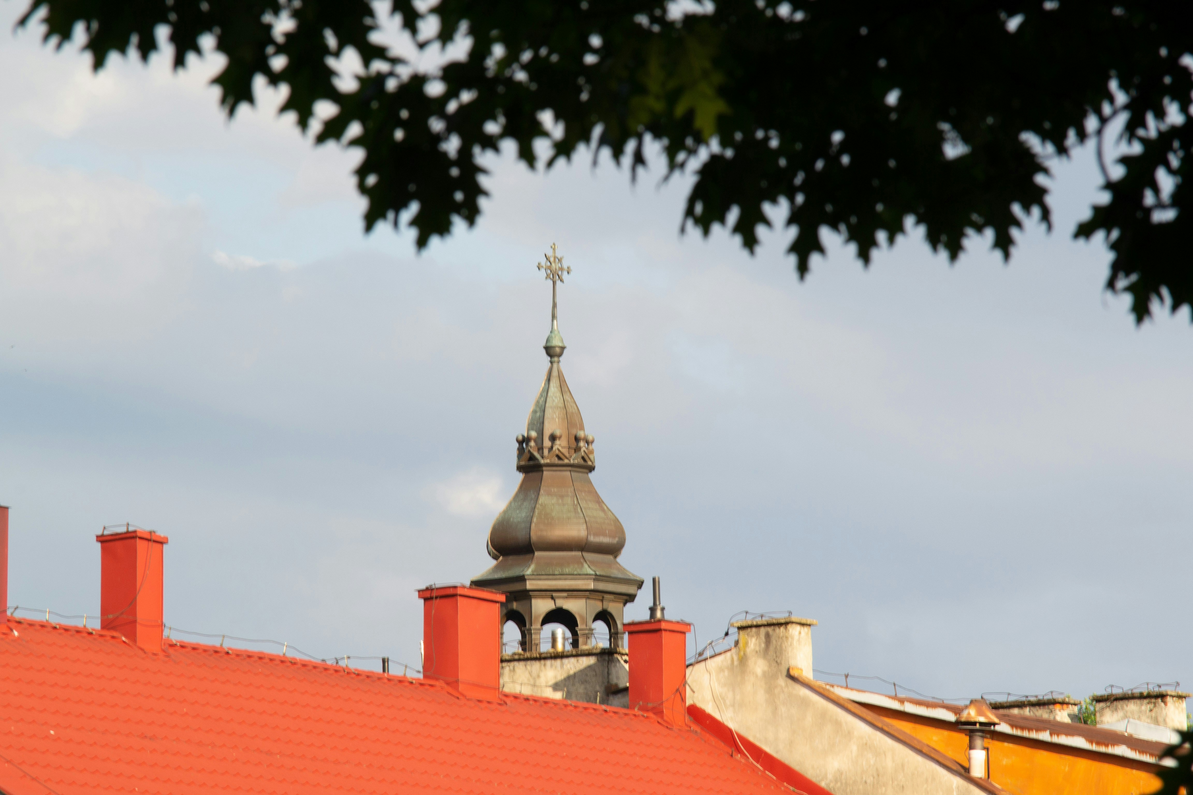 Copper Rooflines Meet a Cloudy Sky at an Old Town Spire