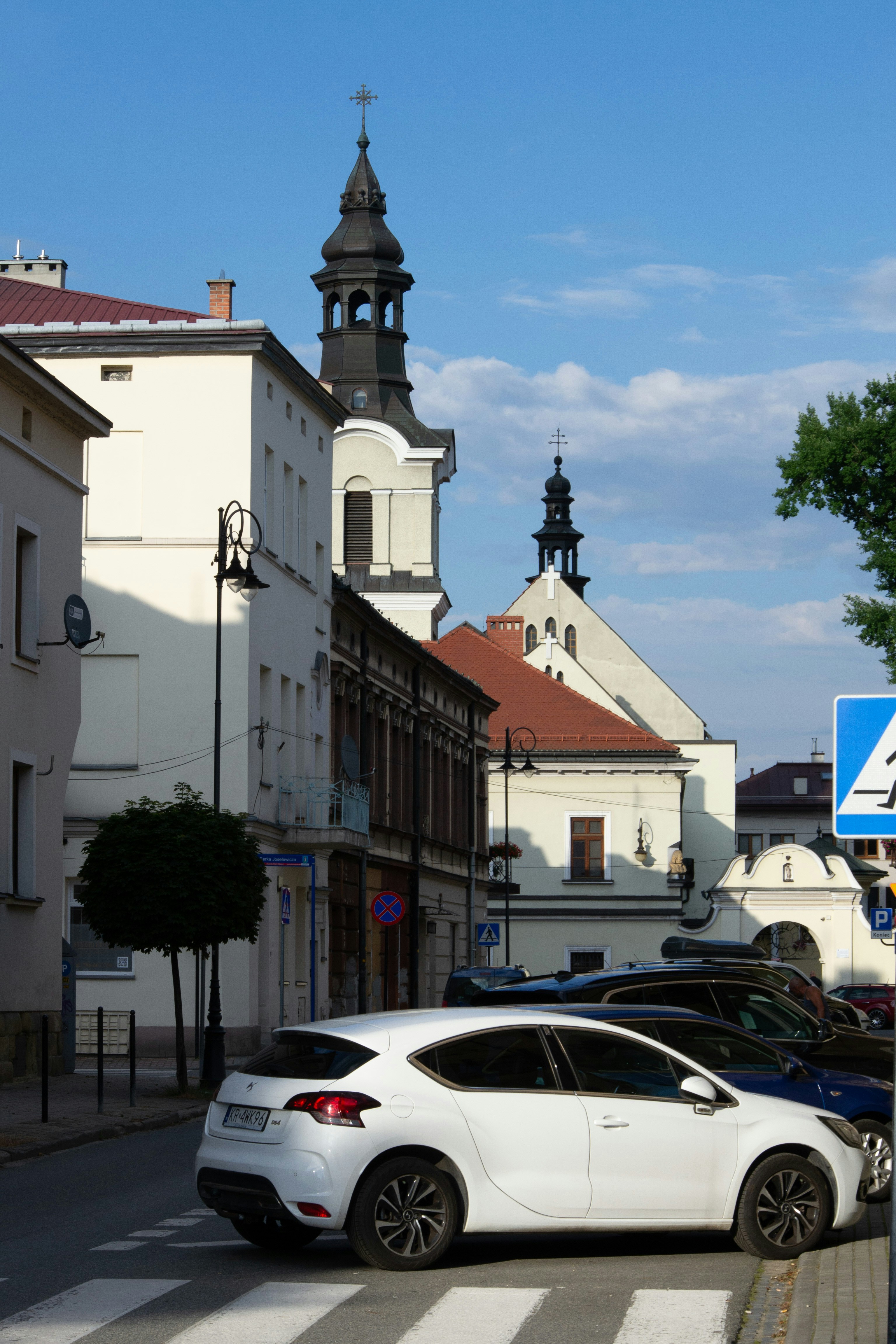 White car under a European churchscape on a sunny day