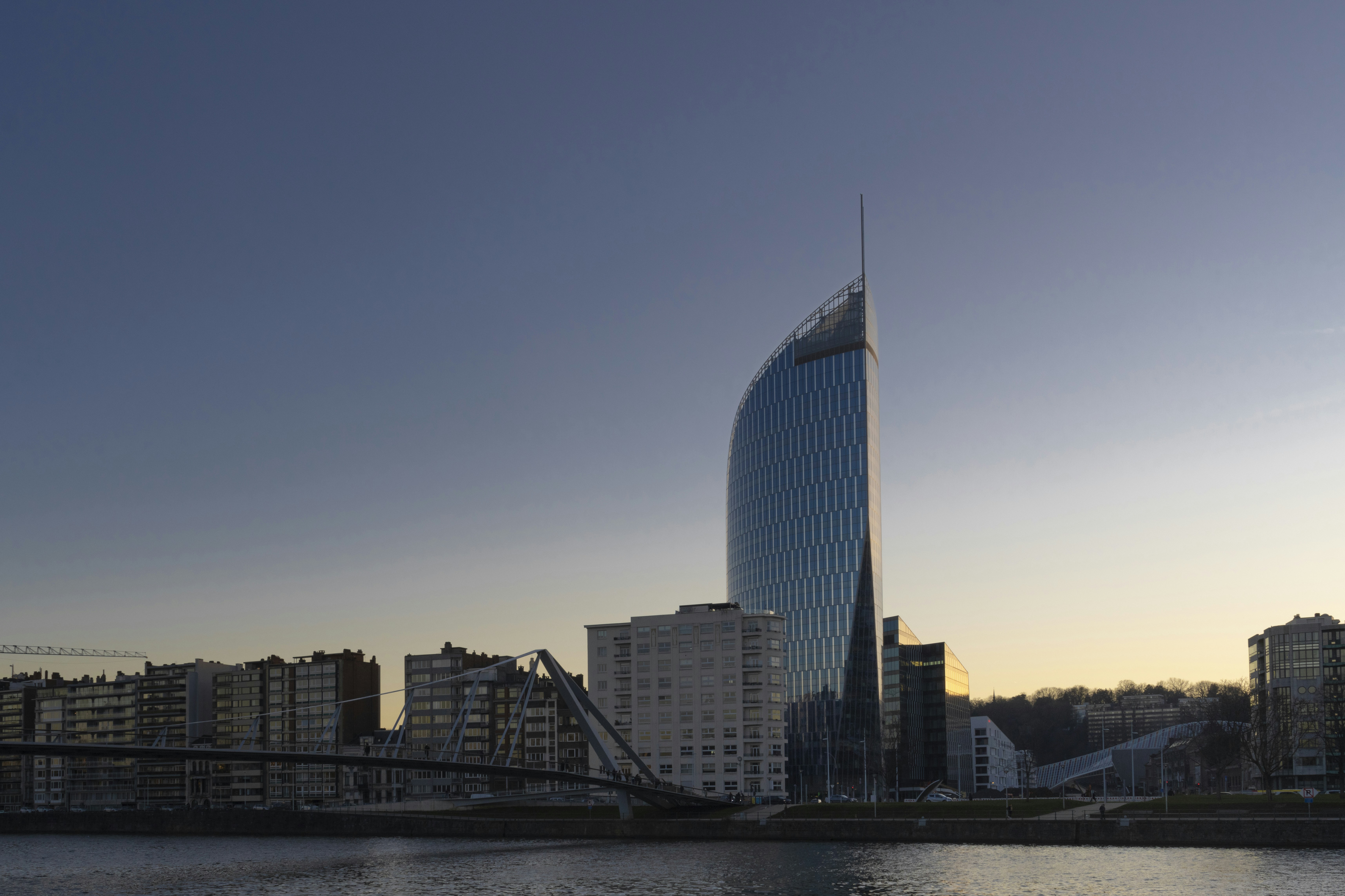 Sinuous Glass Tower Over a Riverside Skyline