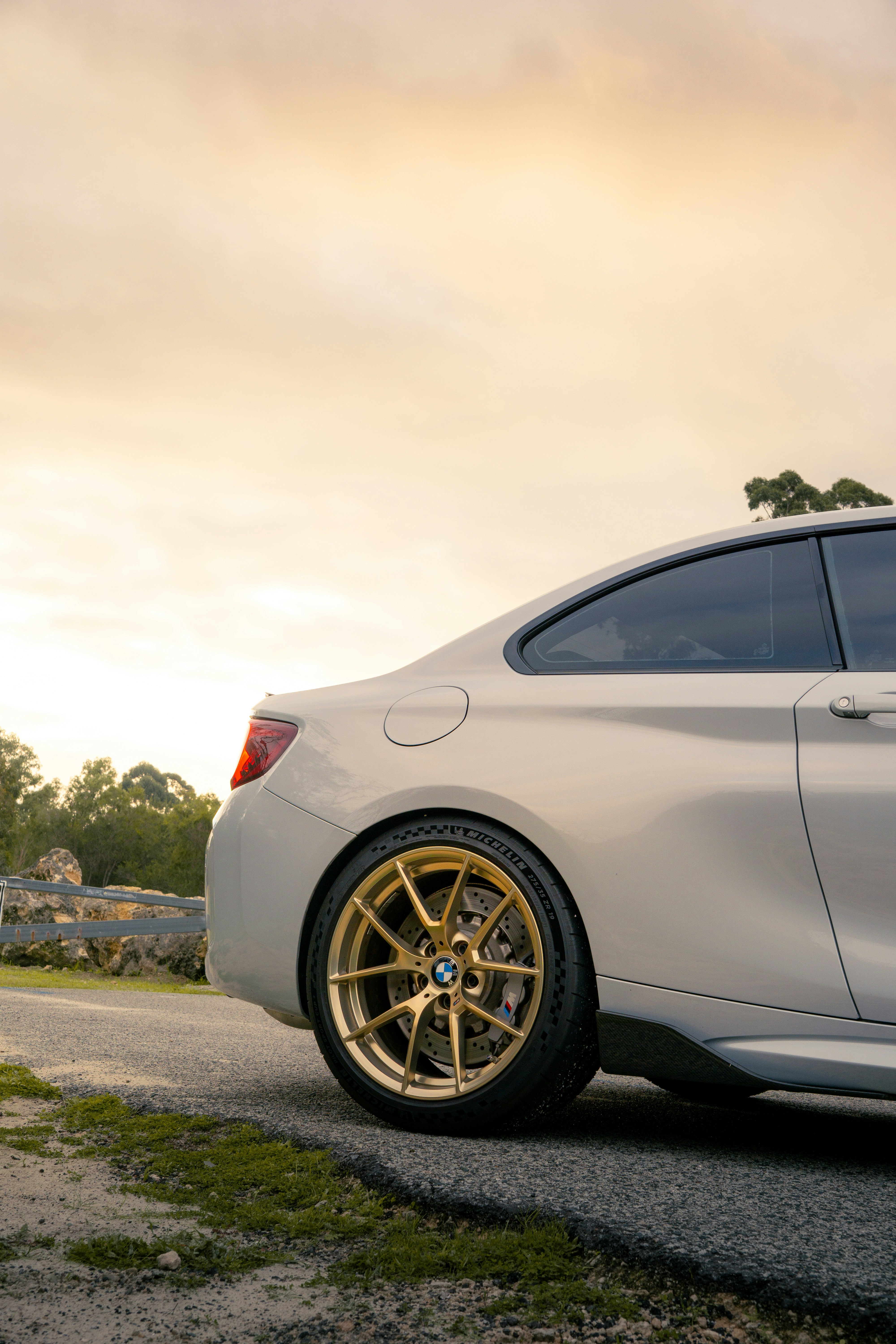 Golden wheels at golden hour: a sleek sedan against a quiet horizon