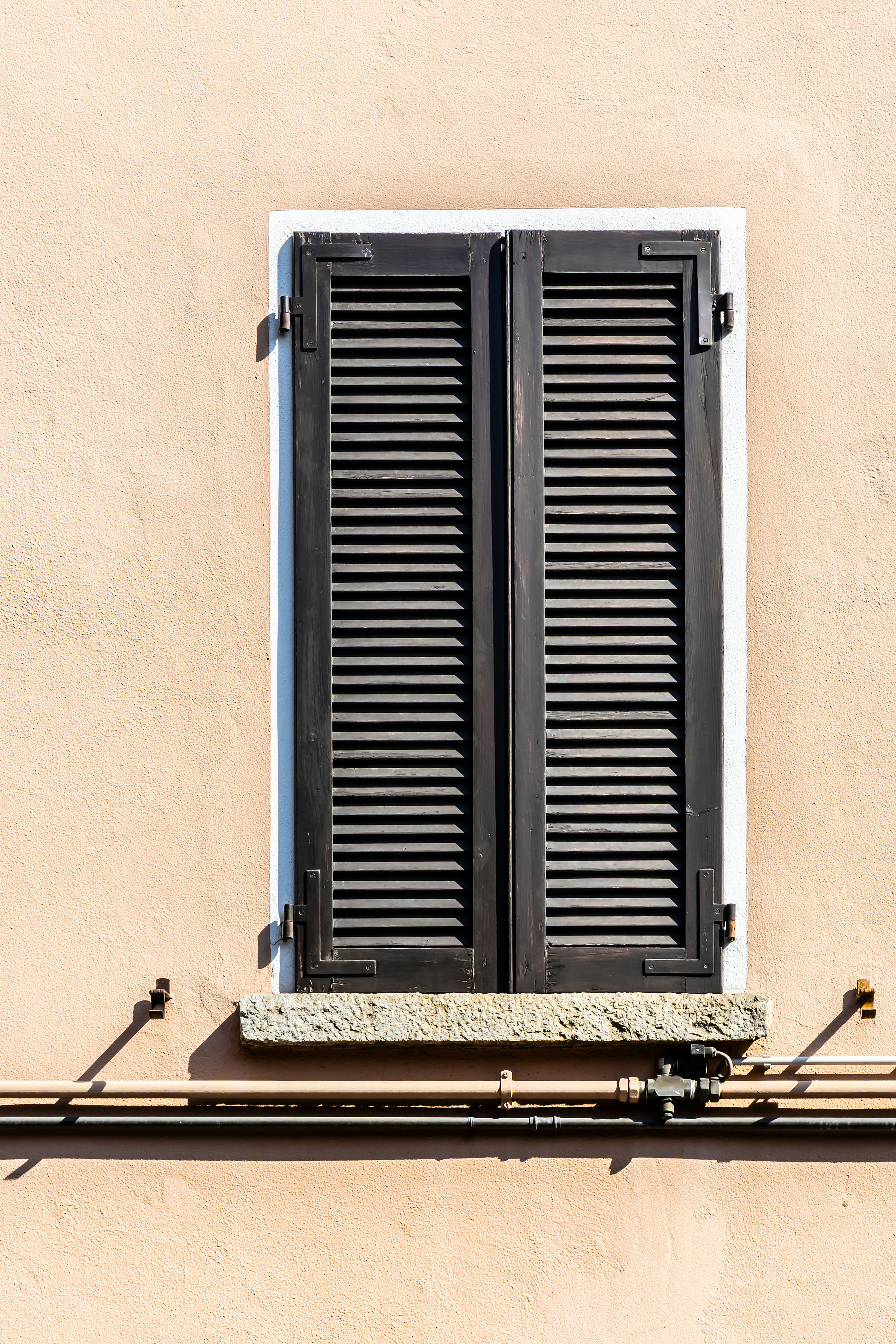 Shuttered Clinic: A Bare Window on a Peach Wall