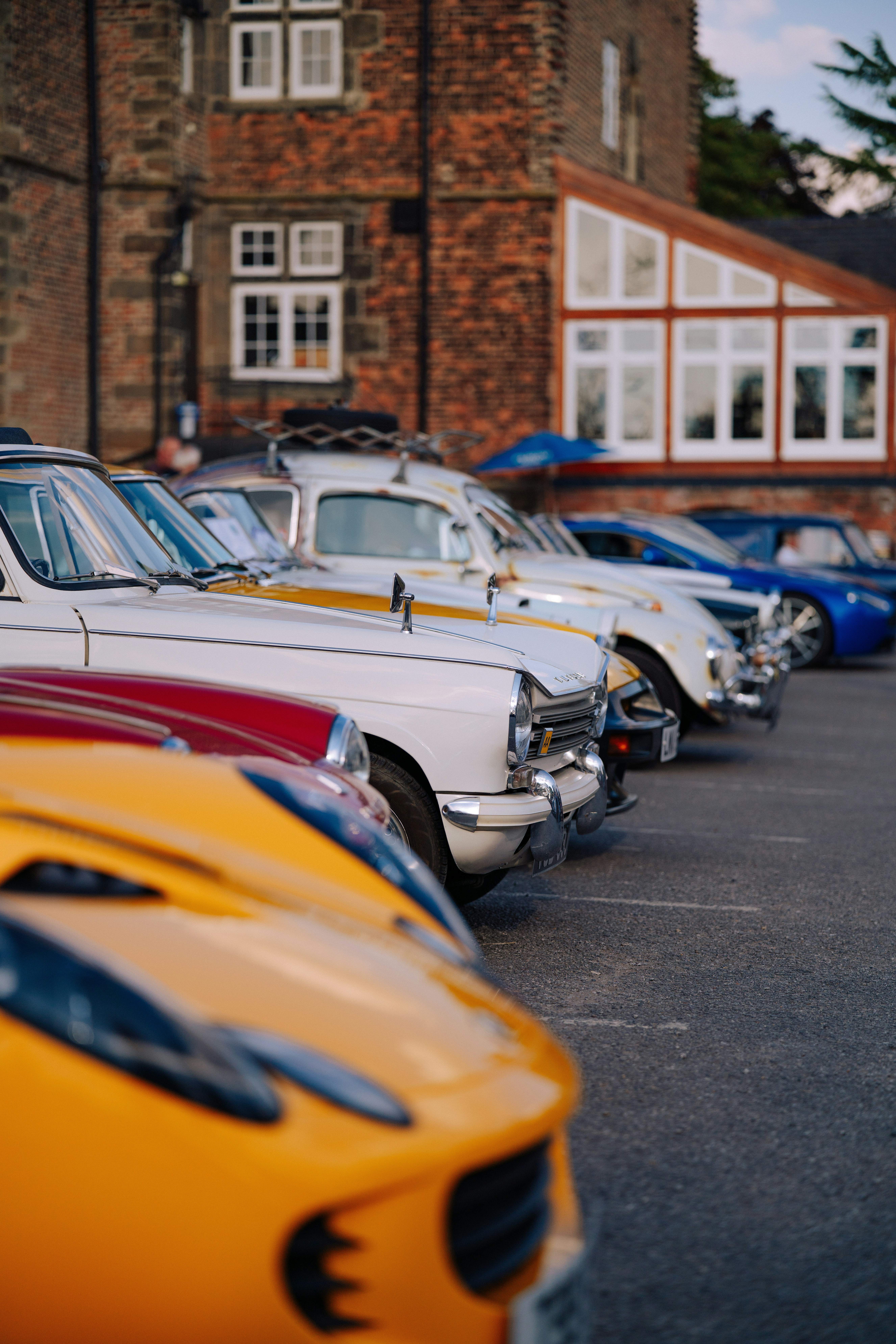 Line of Chromed Classics: A Row of Vintage Cars in a Brickyard Morning