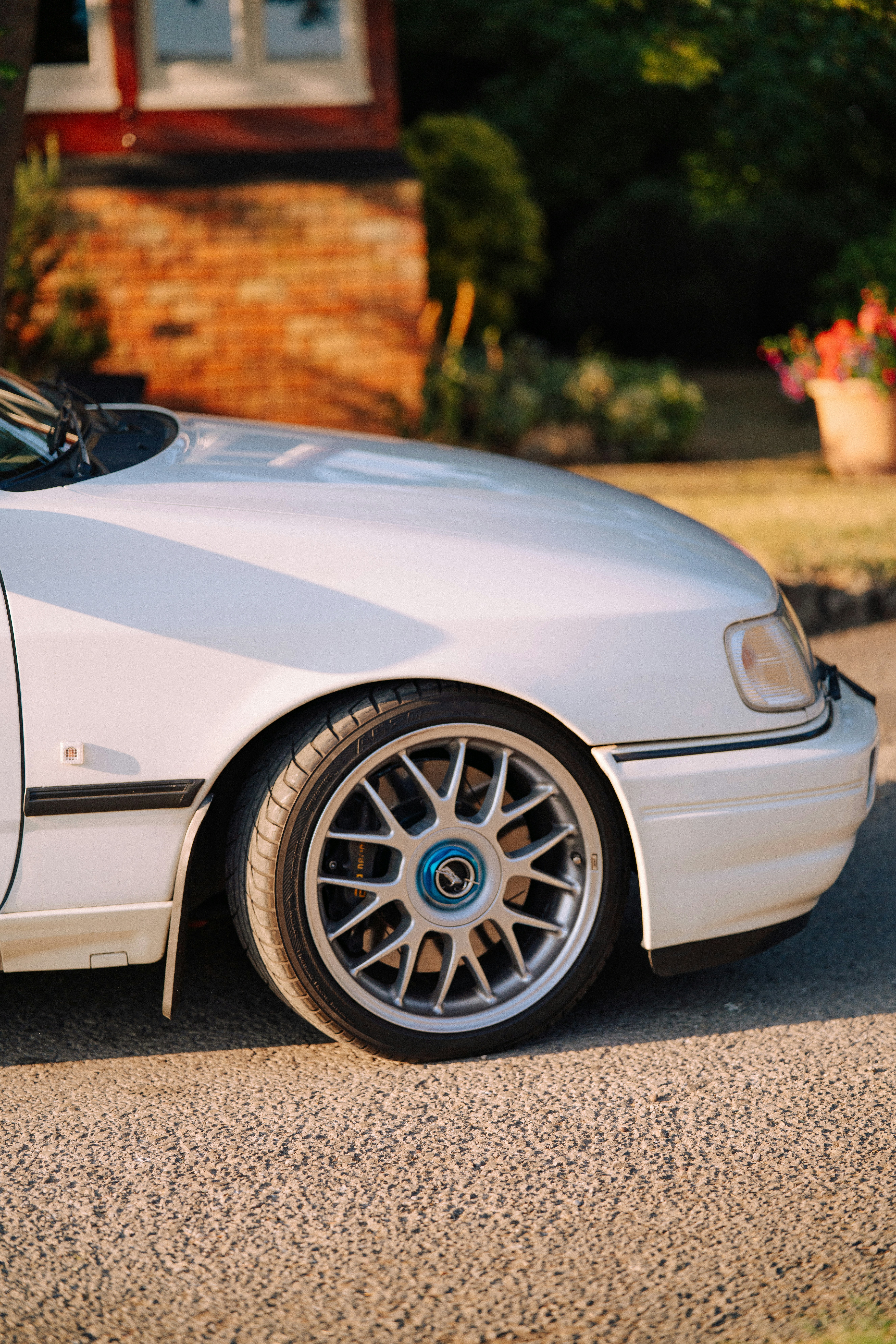 Low-Angle Focus on the Silver Stance: A Classic Car's Front Wheel in the Sun