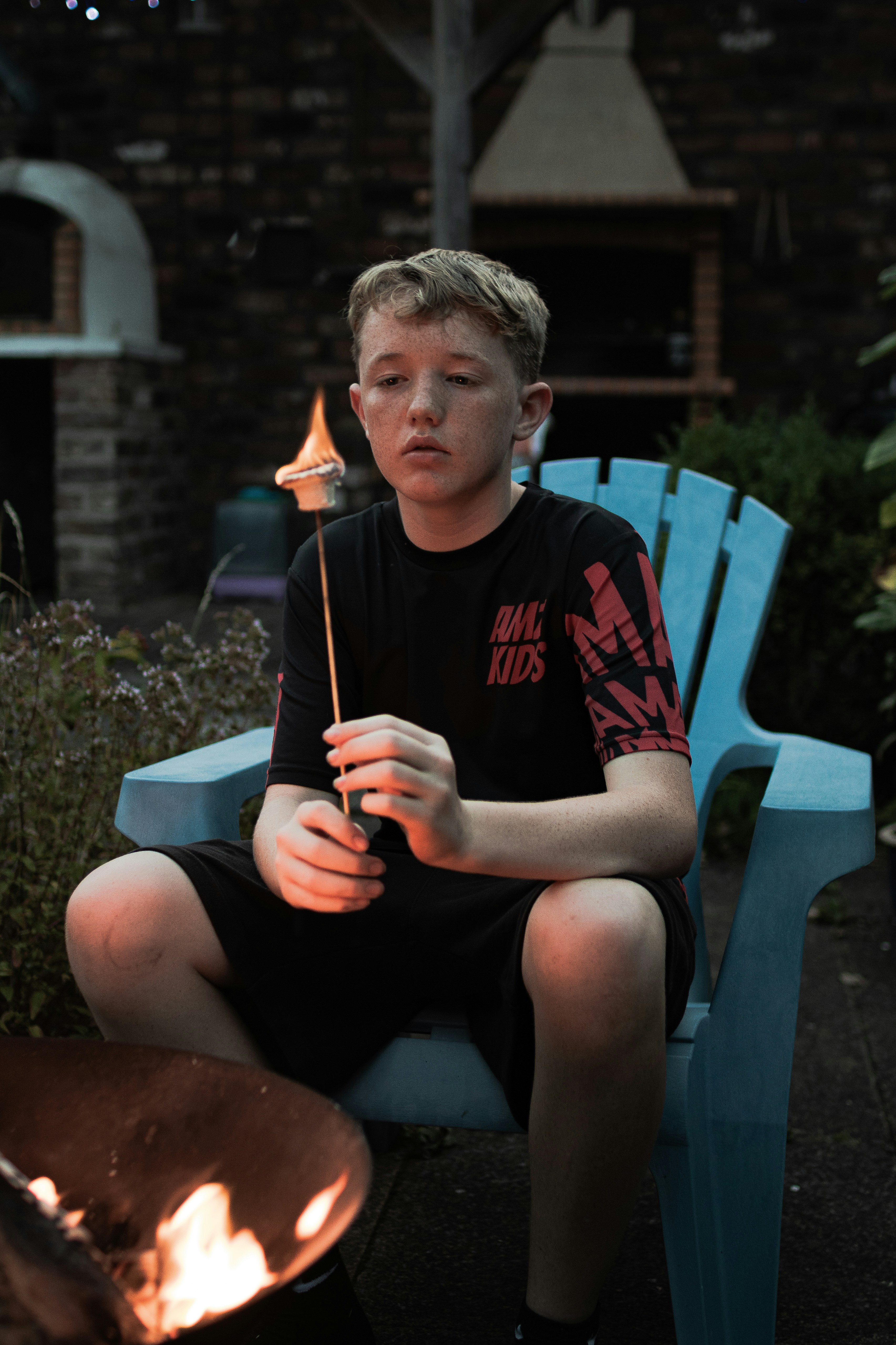 Boy by the Fire: Quiet Focus with a Flaming Skewer