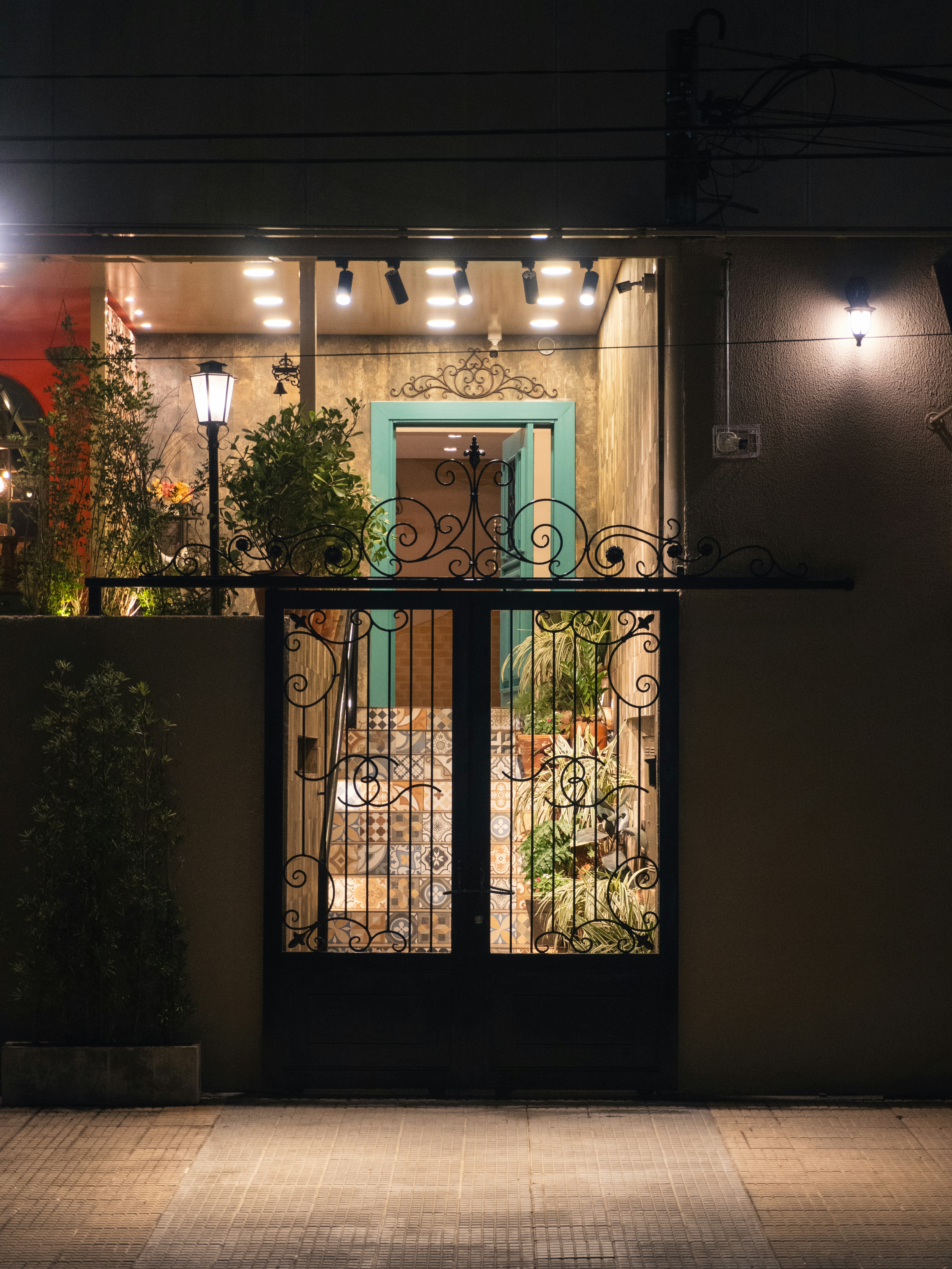 Night Gate to Warm Light: A Wrought-Iron Portal Beckons Inside
