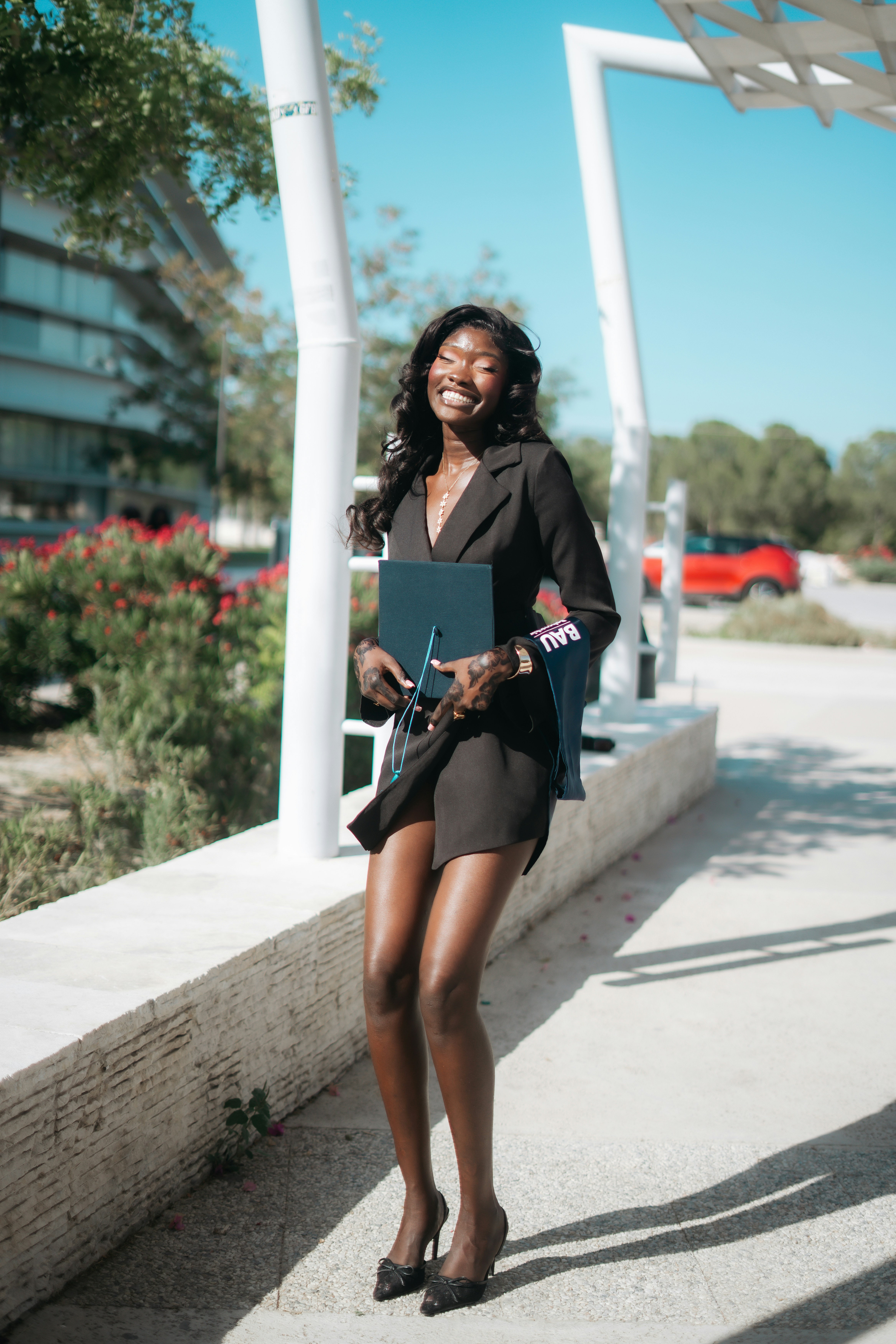 Joyful Graduate in a Bold Black Suit Walking Toward the Lens