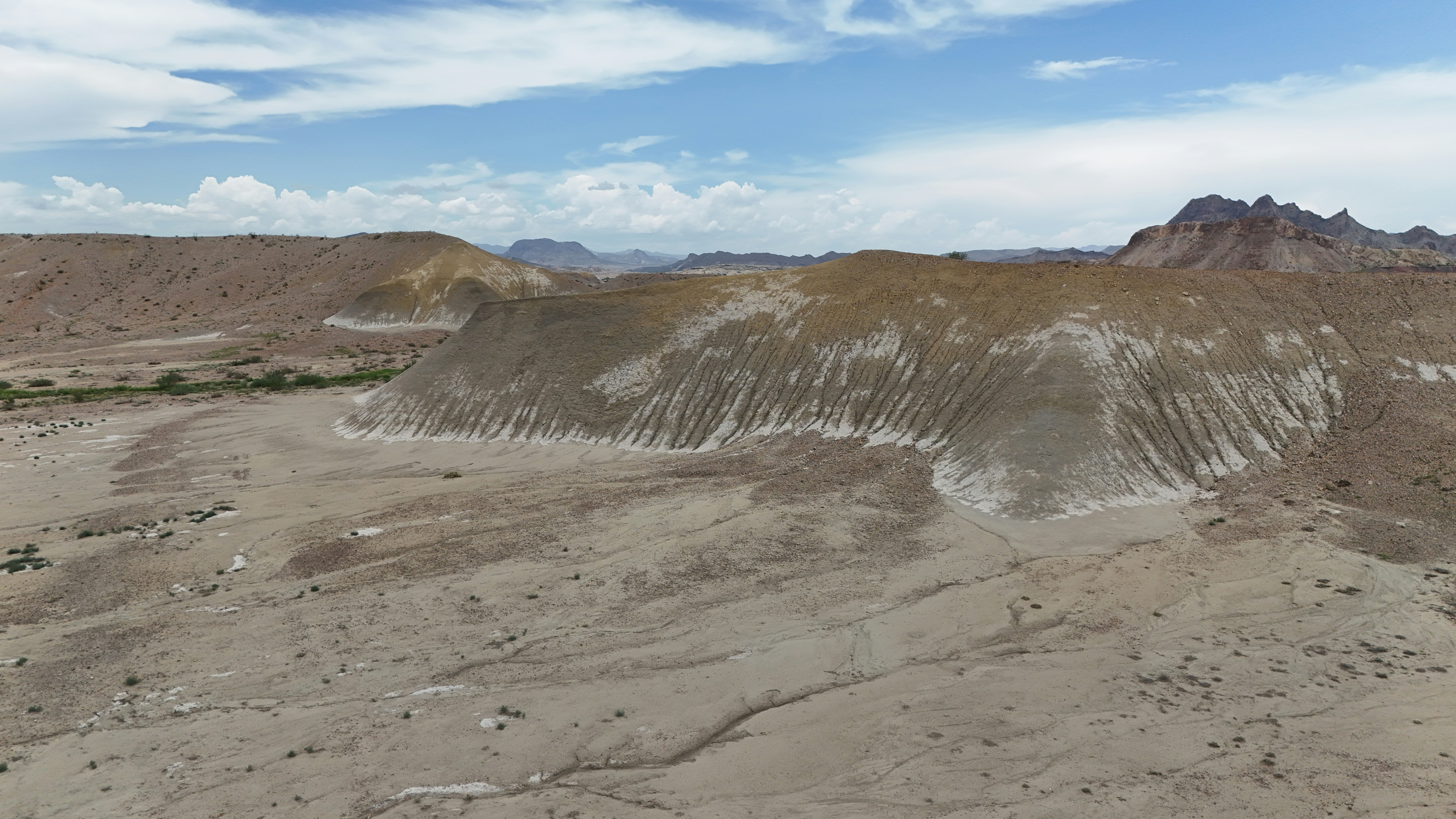 Desert Tidal Plain: Eroded Hills Under Wide Sky