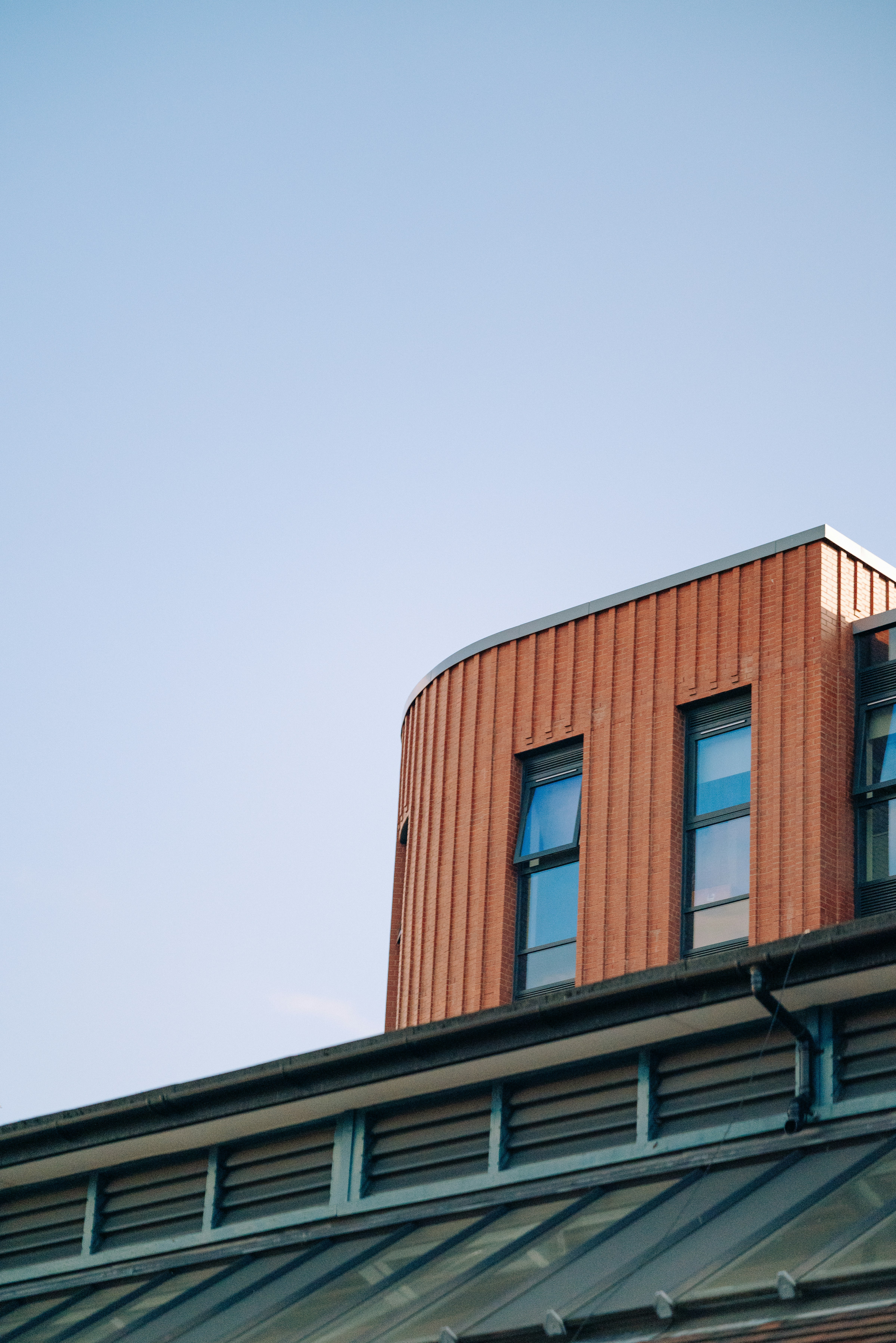 Brick Corner Bettina: Urban Rooftop Geometry against Calm Sky