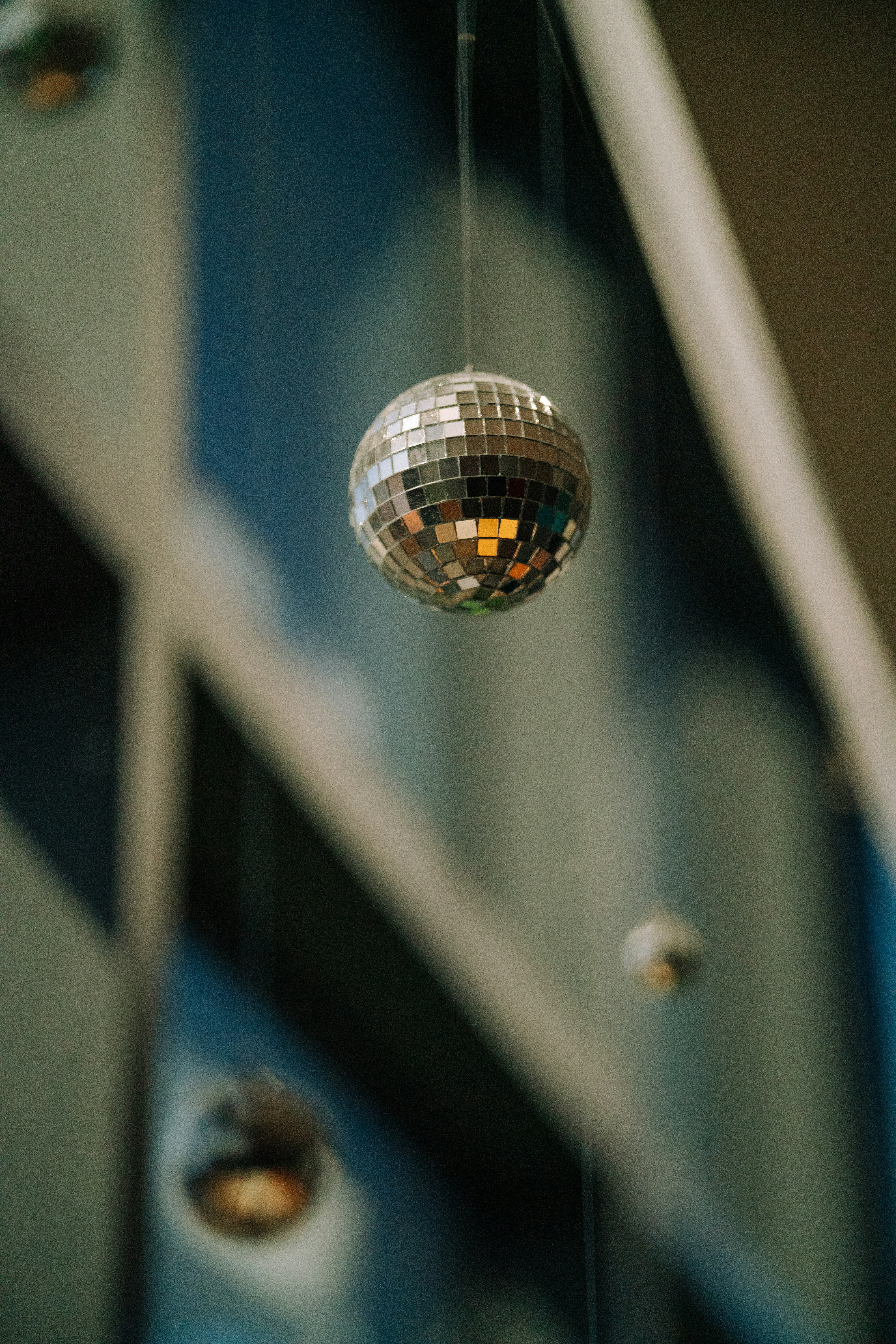 Mirrorball in Motion: A suspended disco orb in a blurred urban interior