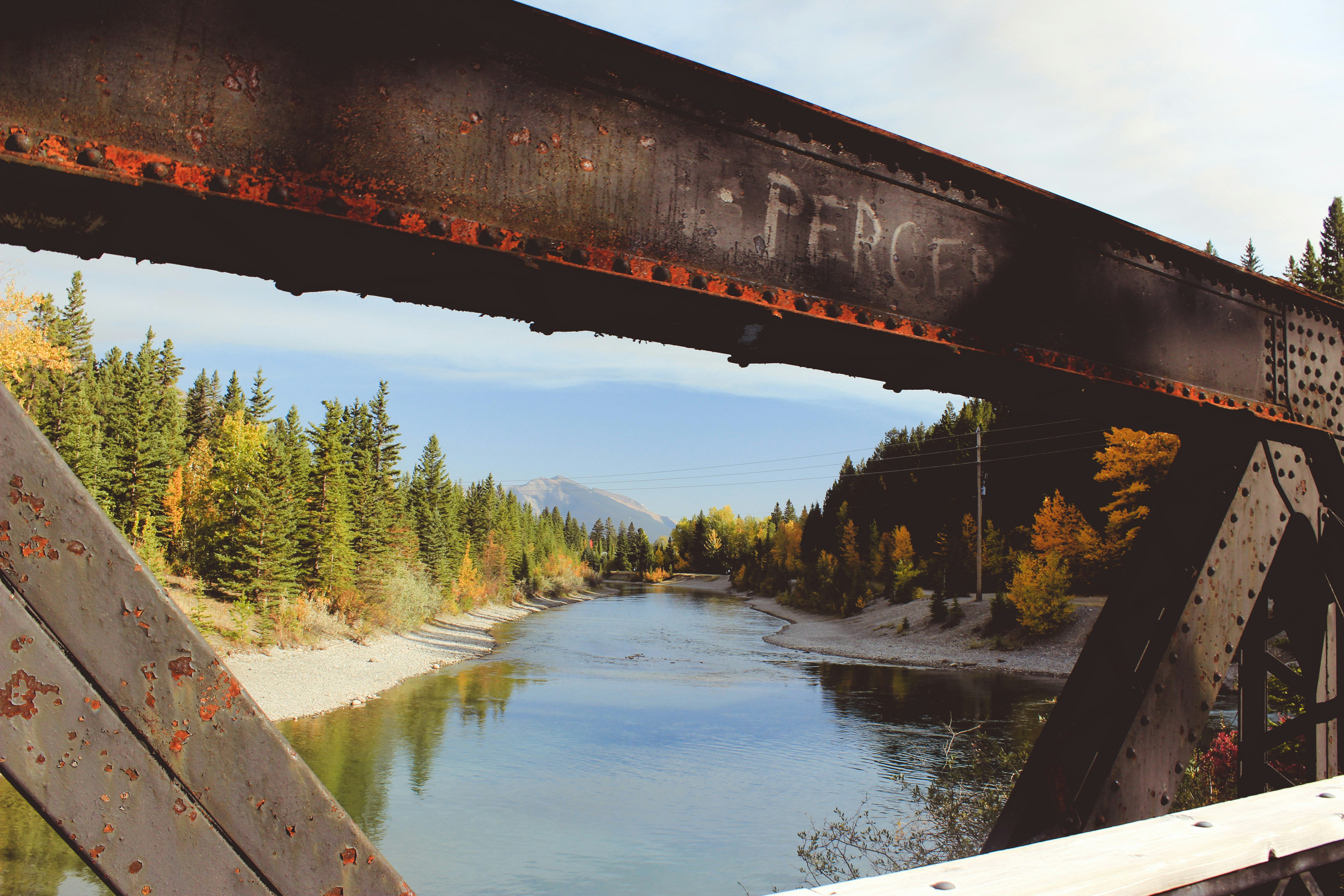 Rusted Bridge Framing a Forested River Bend