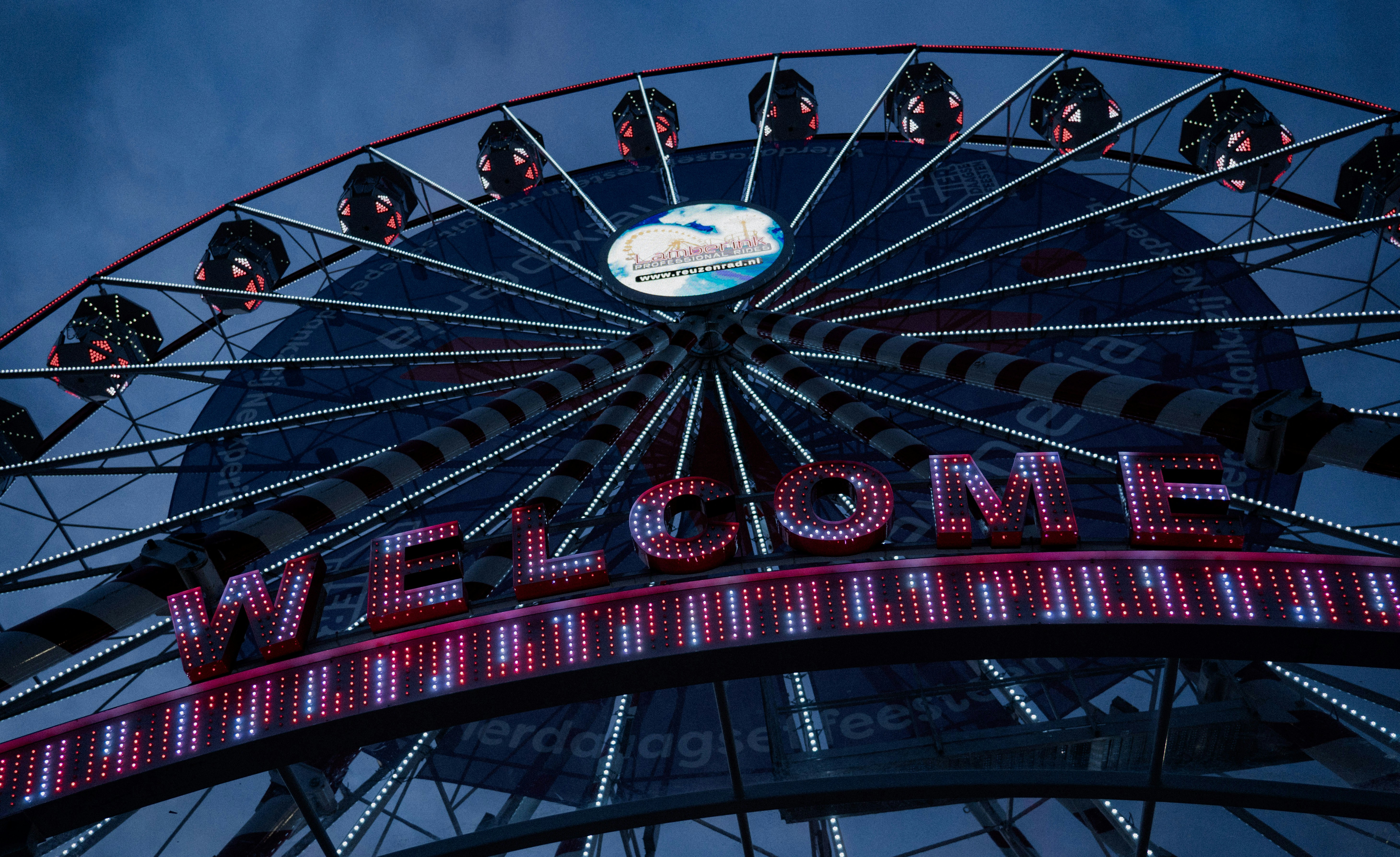 Neon Welcome Wheel: A Nighttime Tilt-Shift of Lights and Rails