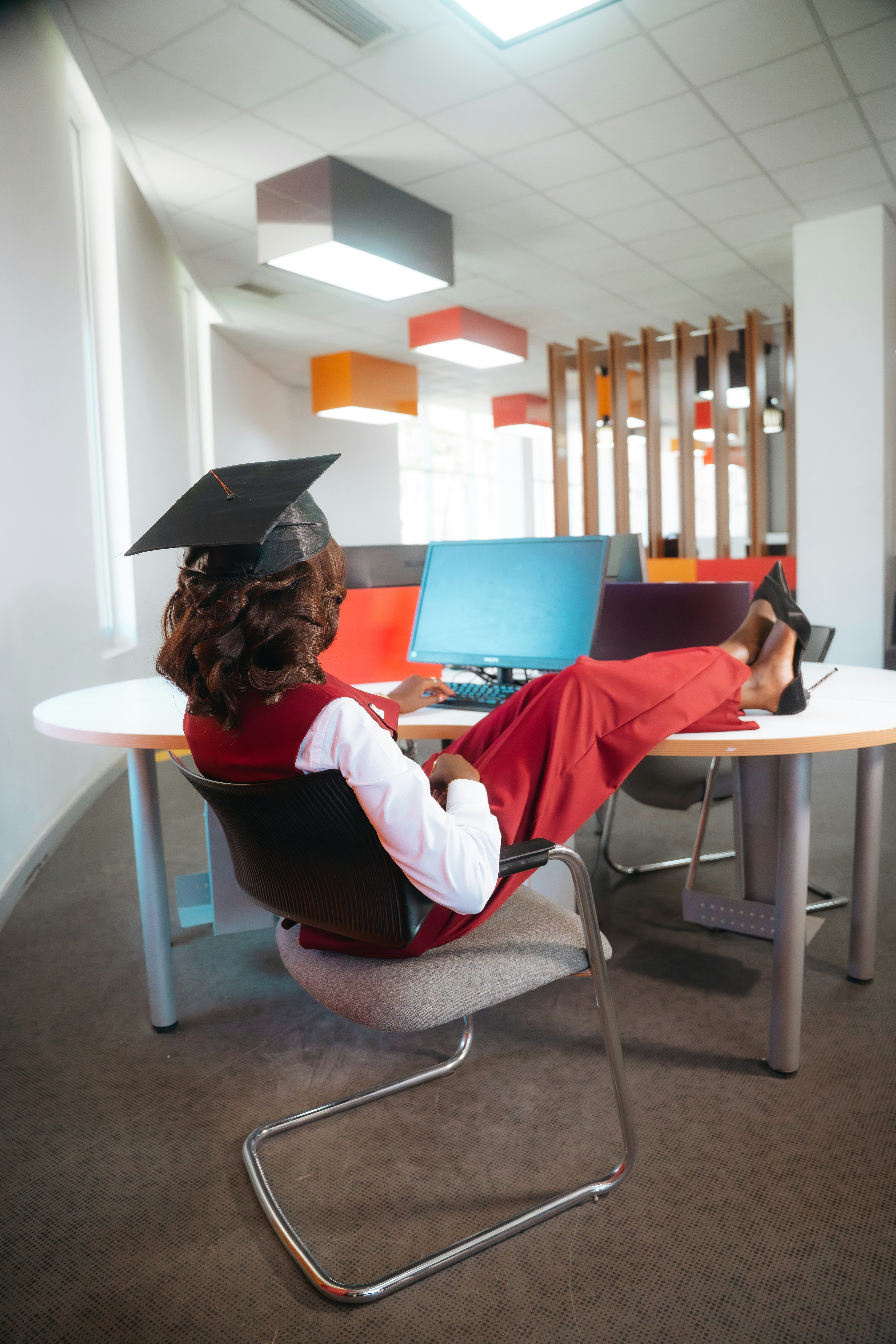 Graduate at the Desk: A Quiet Moment Between Caps and Screens