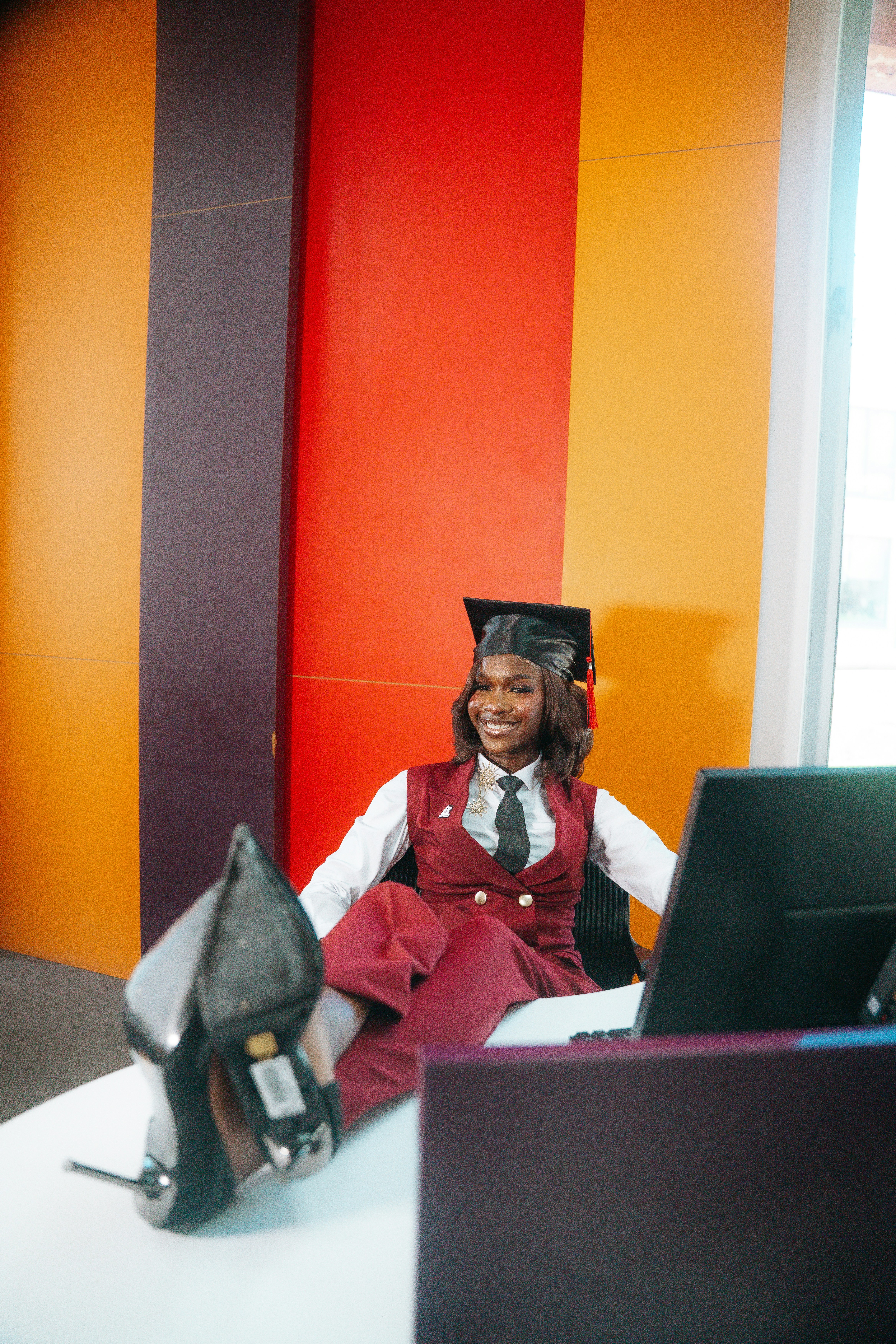 Graduate in Burgundy: A Confident Moment at the Laptop