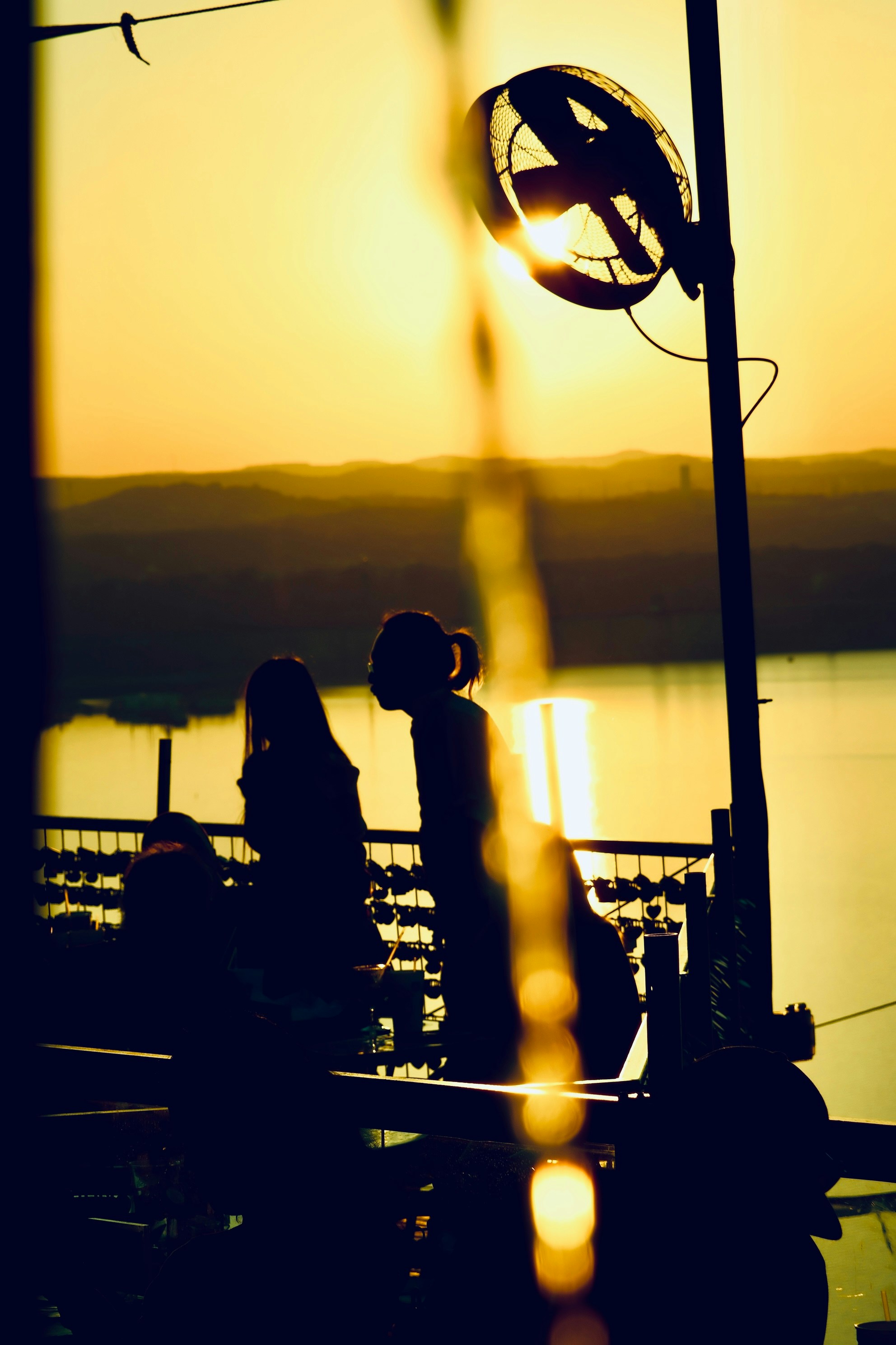 Silhouettes at Sunset: A Quiet Moment by the Water