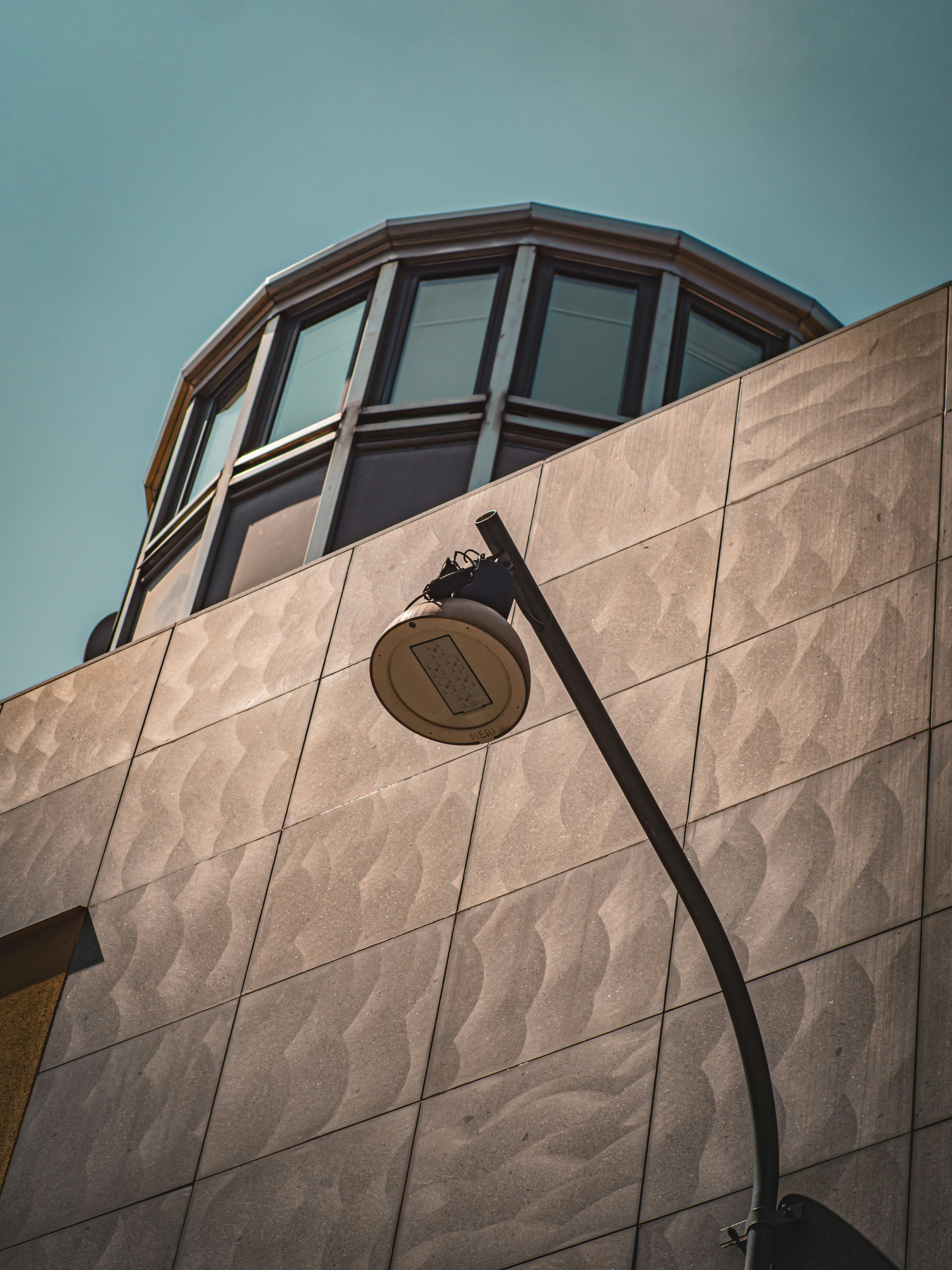 Curved Glass Tower Above a Textured Facade