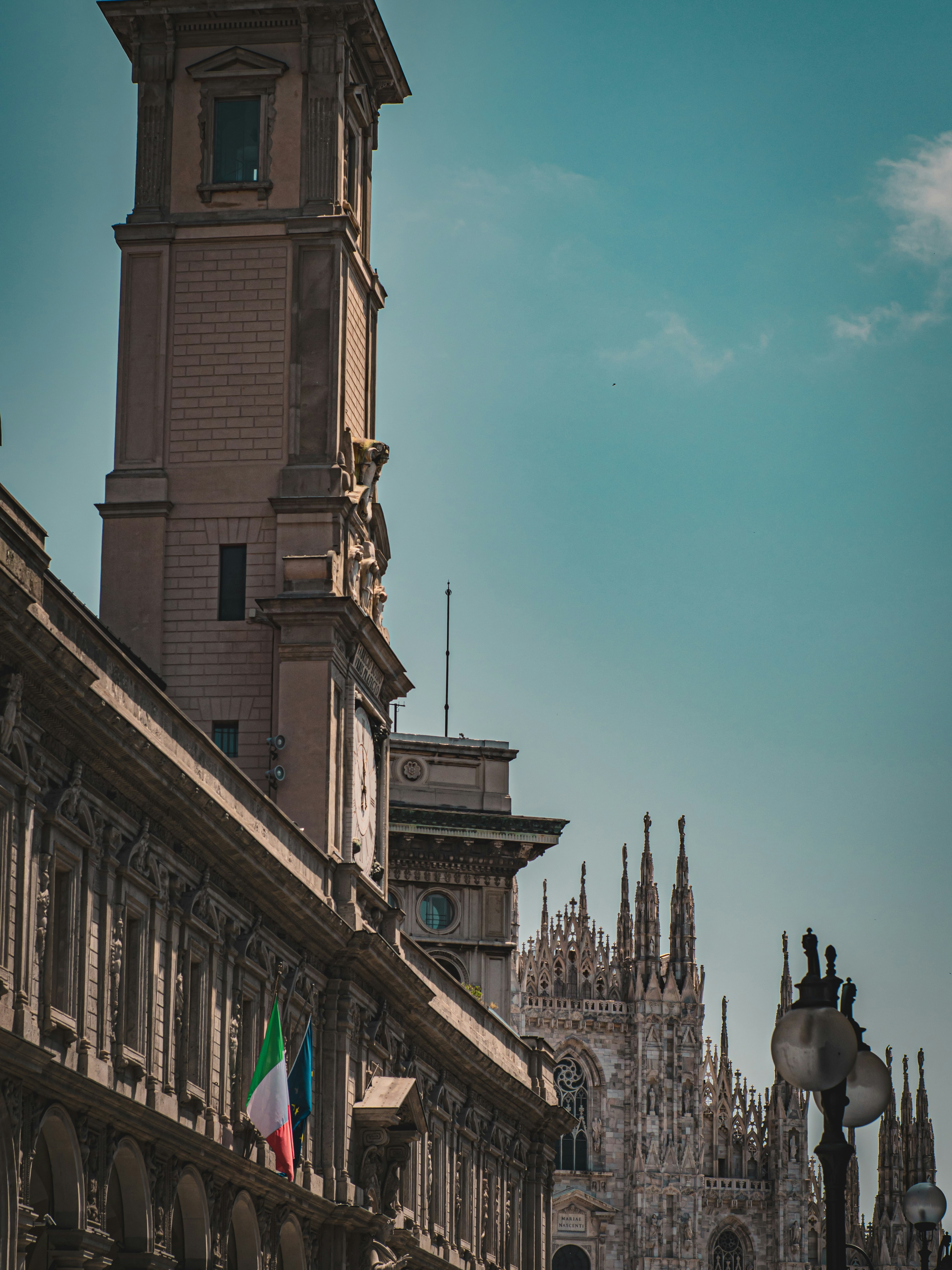 Clocktower and Gothic Silhouette: A Street-Level View Toward Milan Cathedral