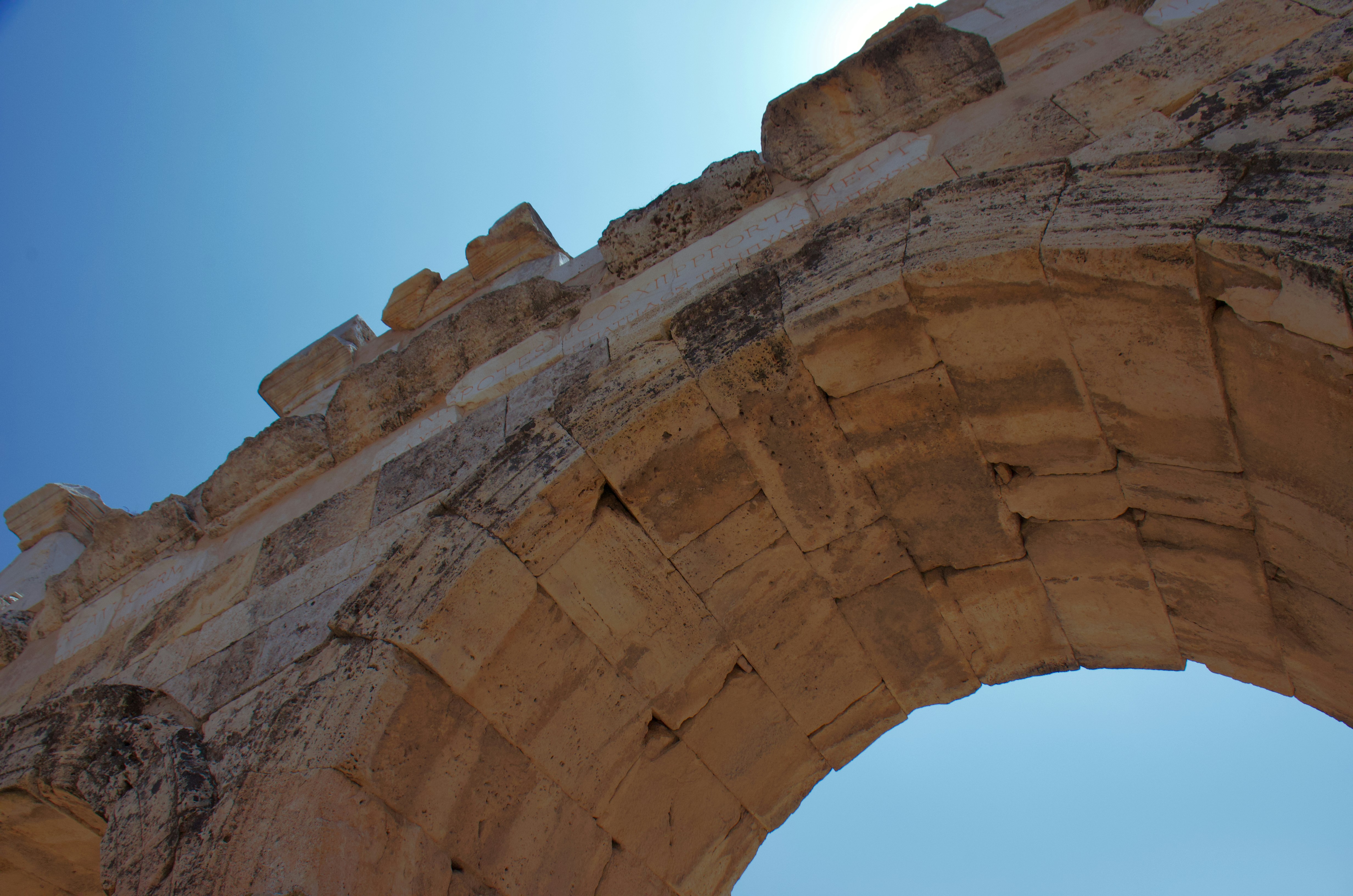 Arch of Stone Echoes: A Weathered Curvature Against a Clear Sky