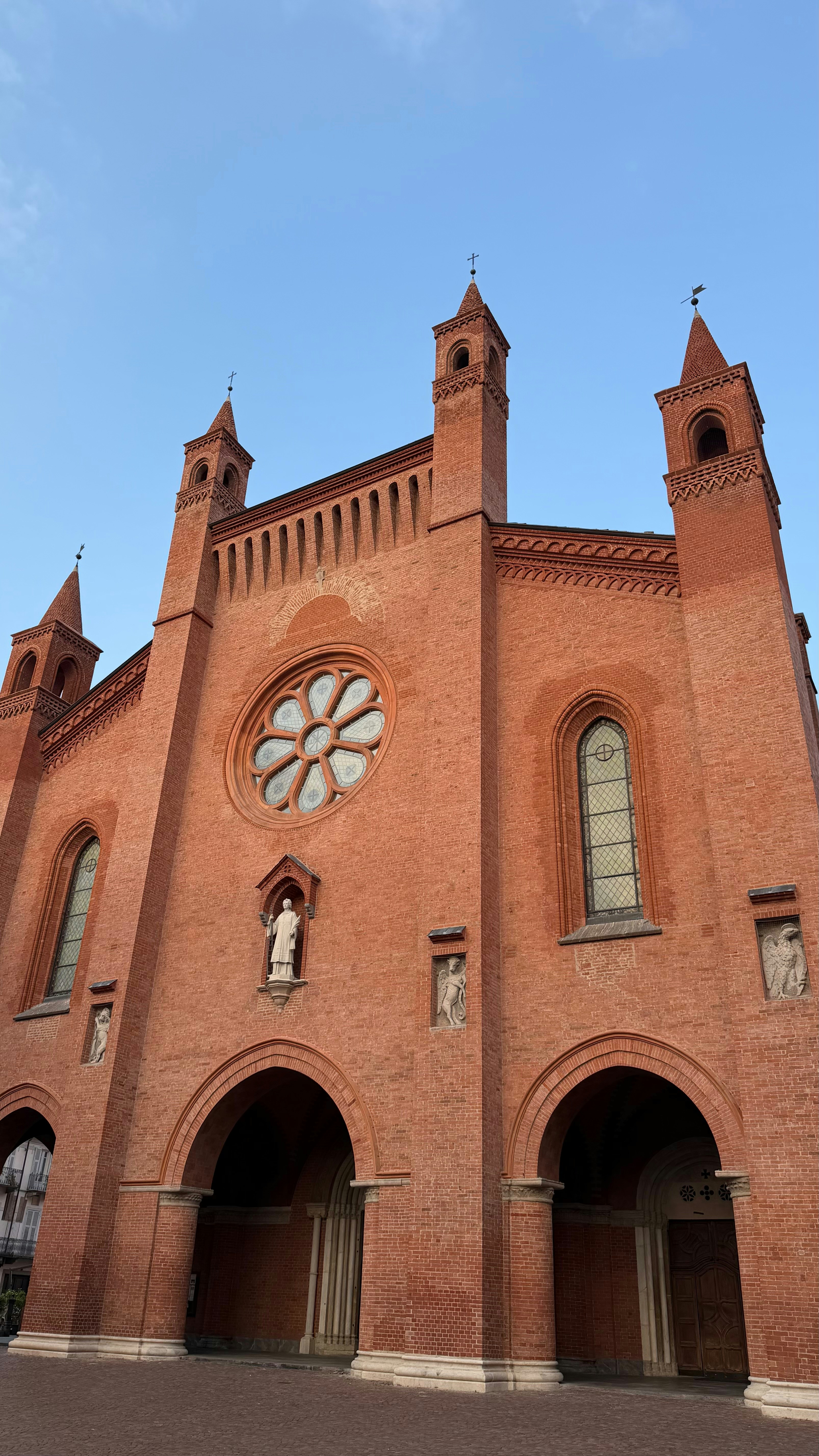 Brick Cathedral Ascending: Gothic Towers Framing a Central Rose Window