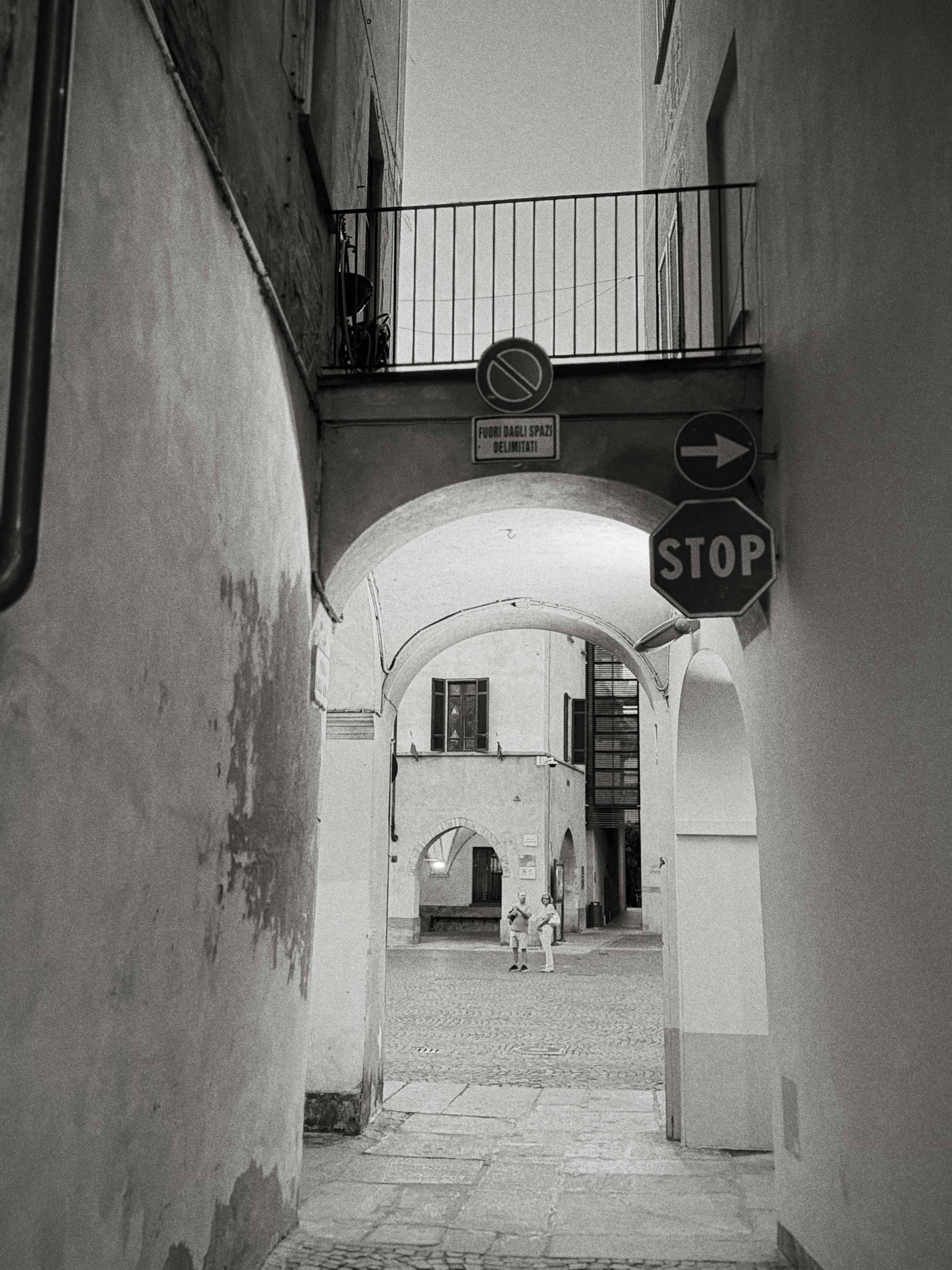 Archway Corridor with Stop Sign: Quiet Passage Through an Old Town