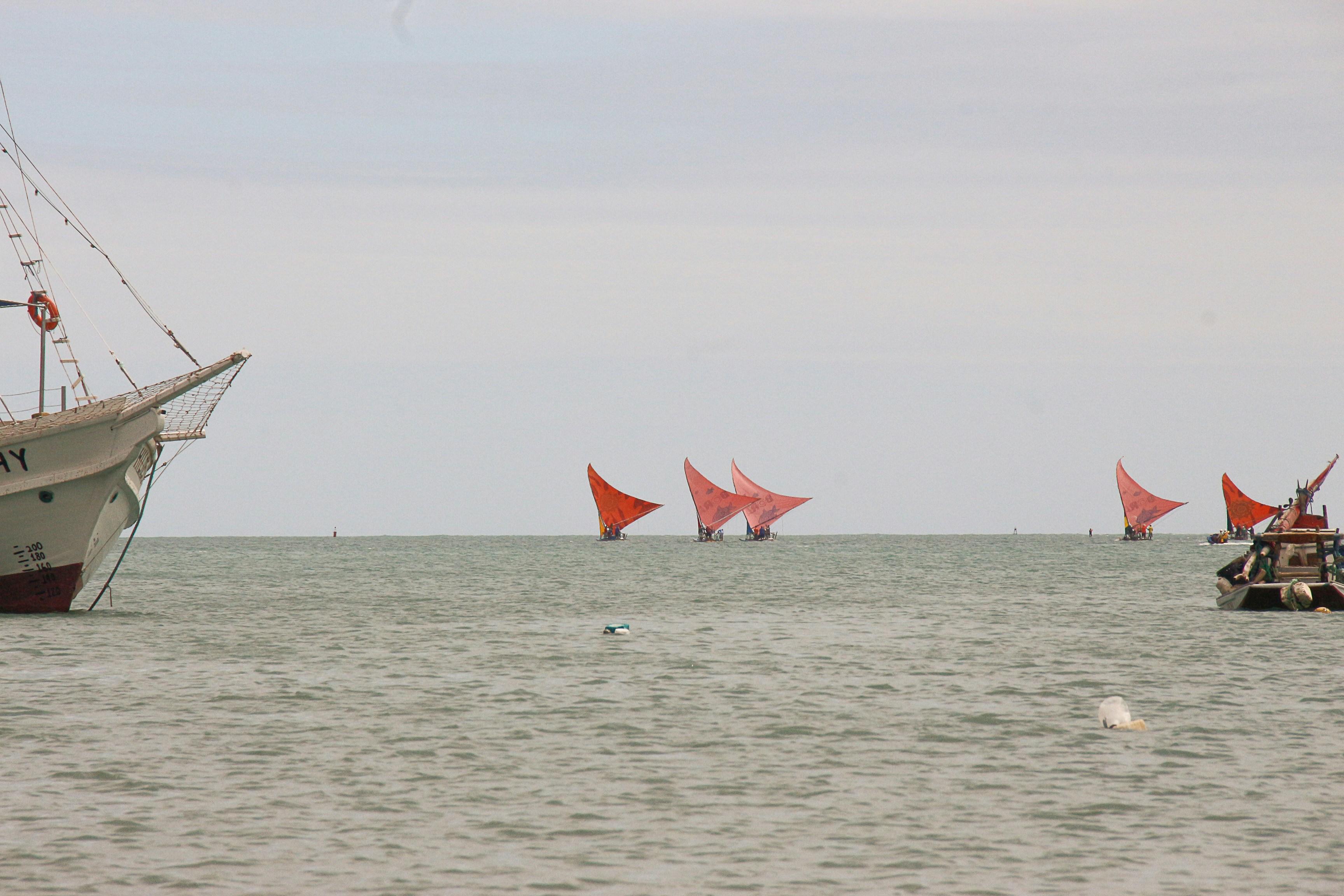 Awaiting the Tide: Masts with Red Sails at Quiet Horizon