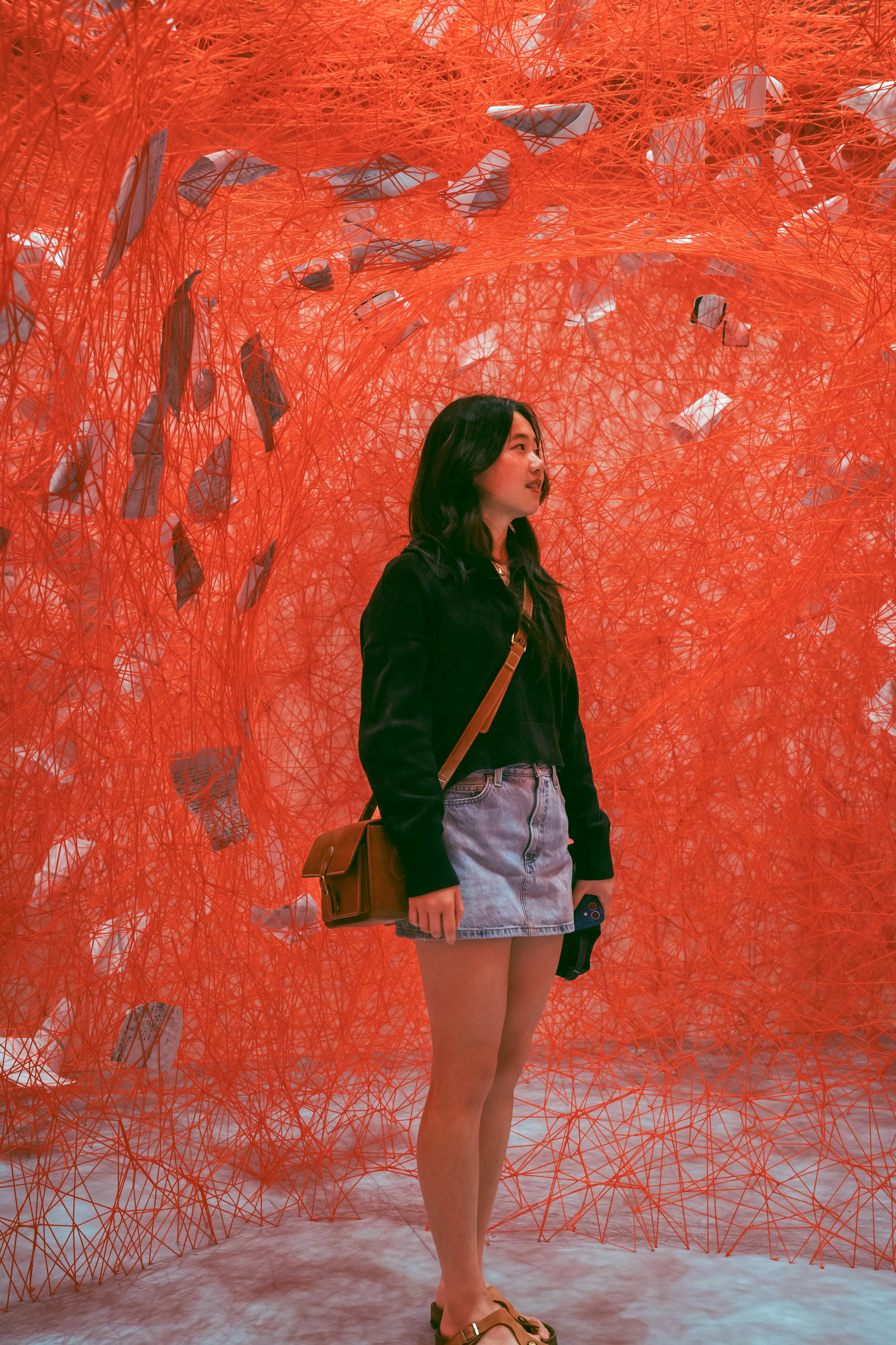 Crimson Web: A Young Woman Surrounded by a Field of Red Threads