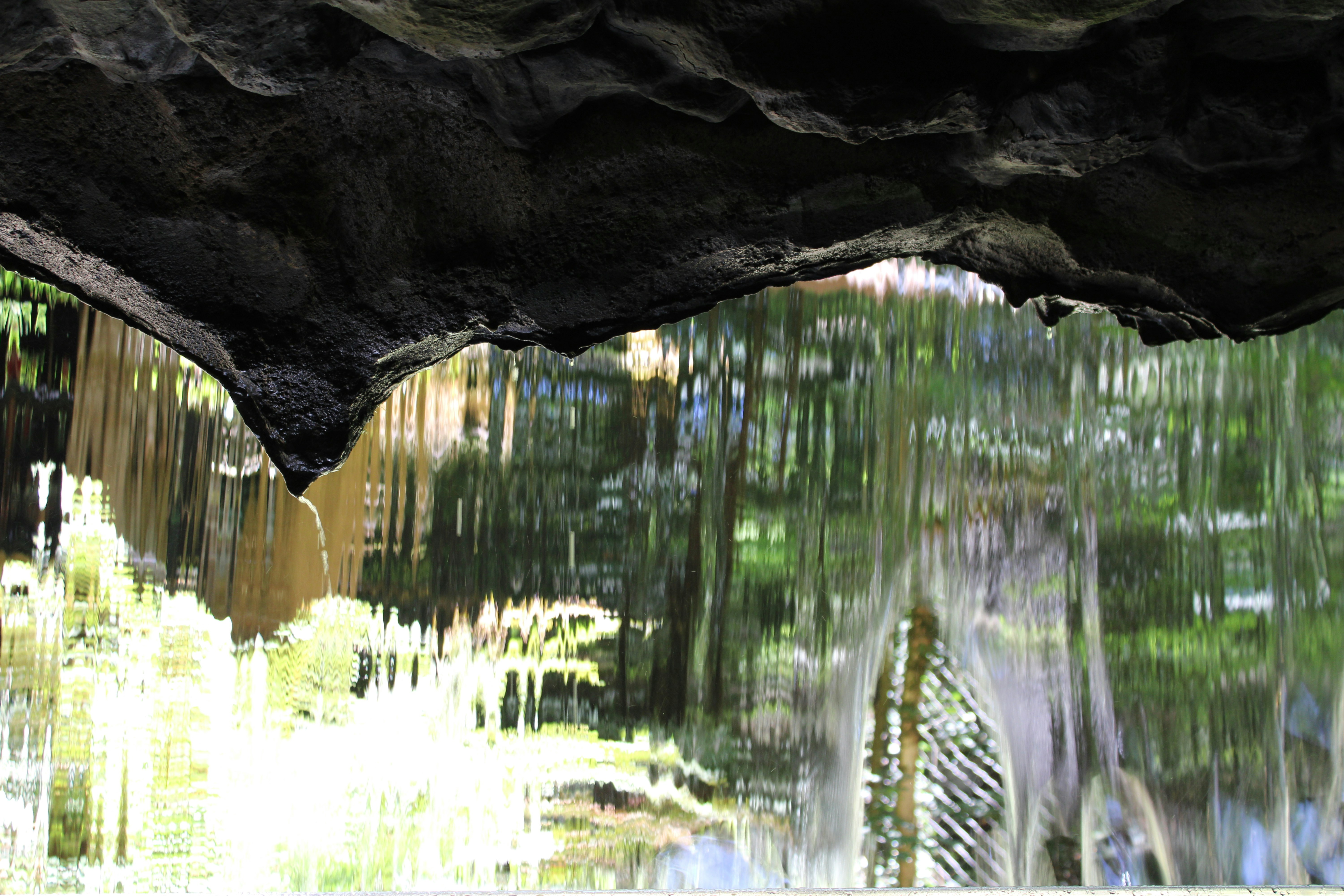 Under the Veil of Rock: A Silhouette in a Moving Waterfall