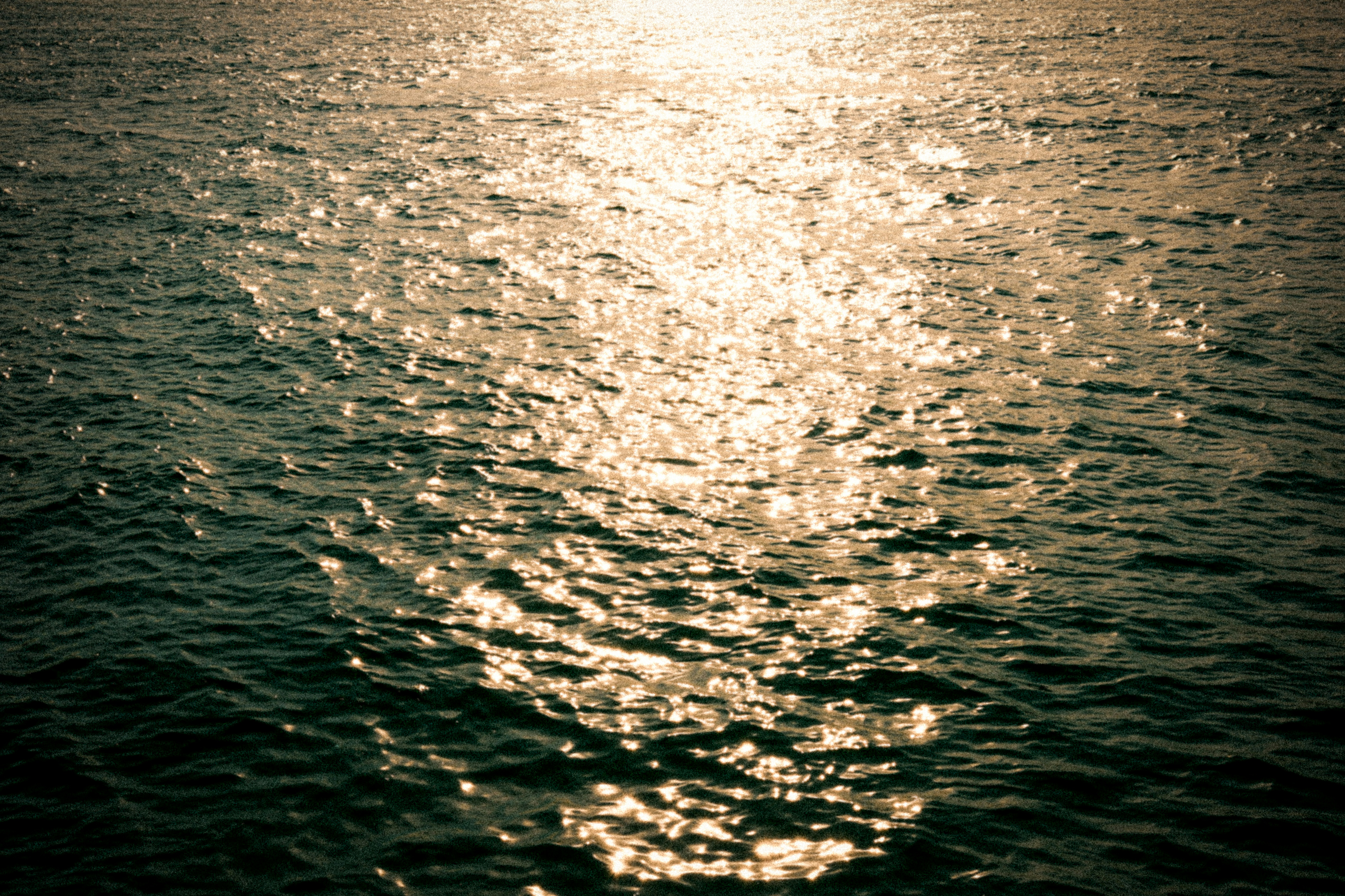 Glittering Horizon: Sunlit Ripples Across an Open Sea