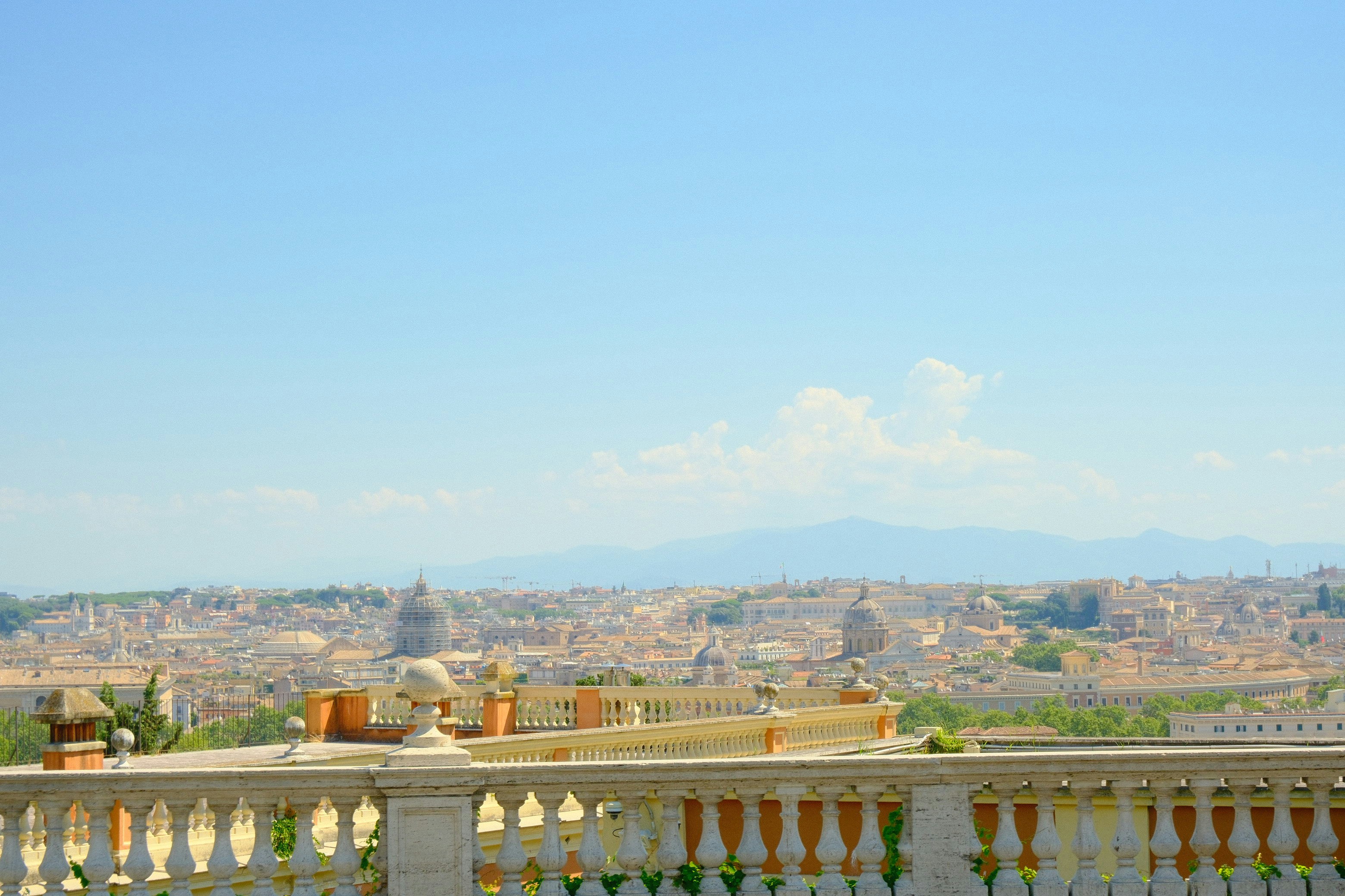 Terraced balustrade framing a sunlit Roman horizon