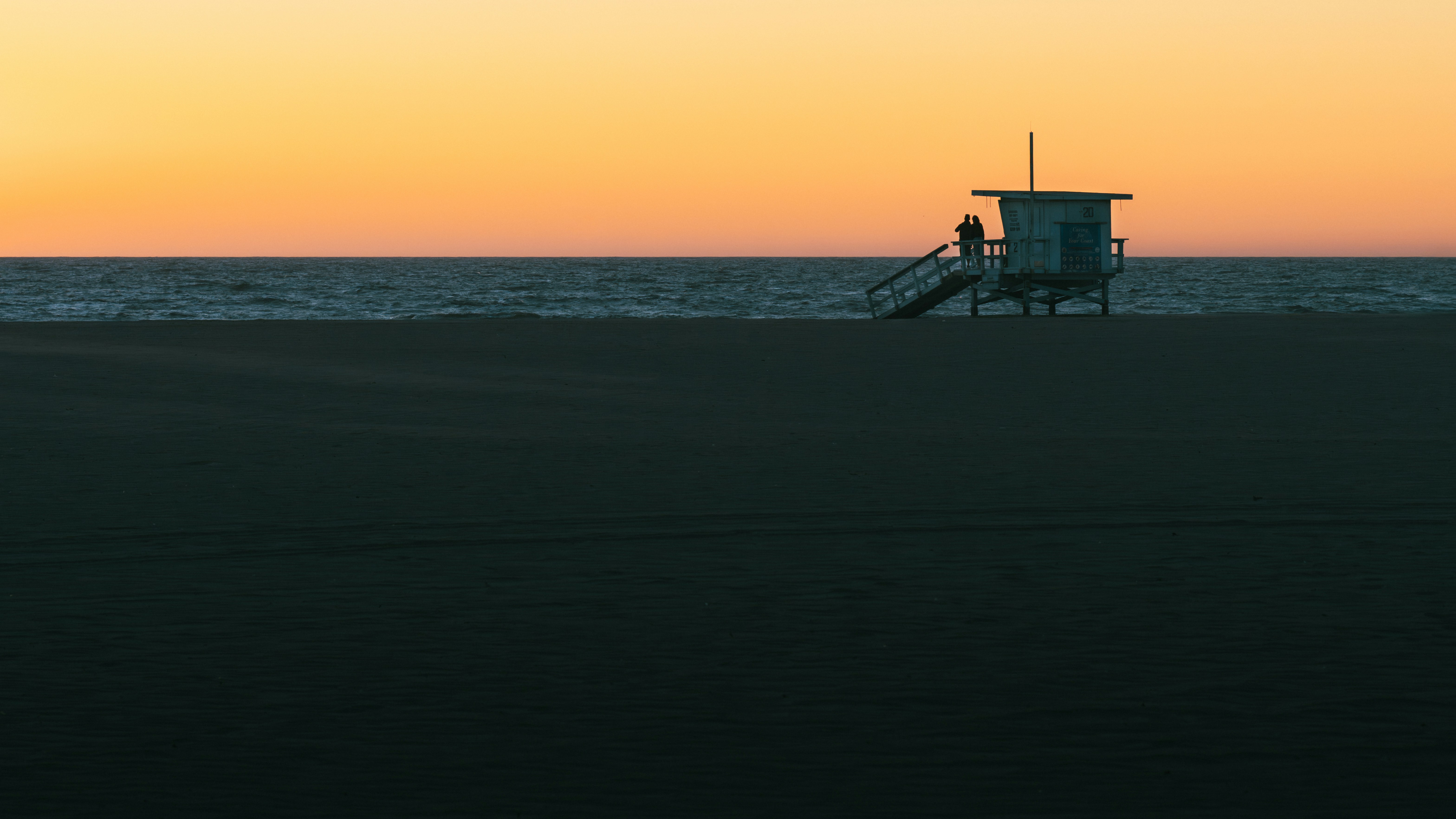 Lifeguard Tower at Dusk Over Quiet Surf